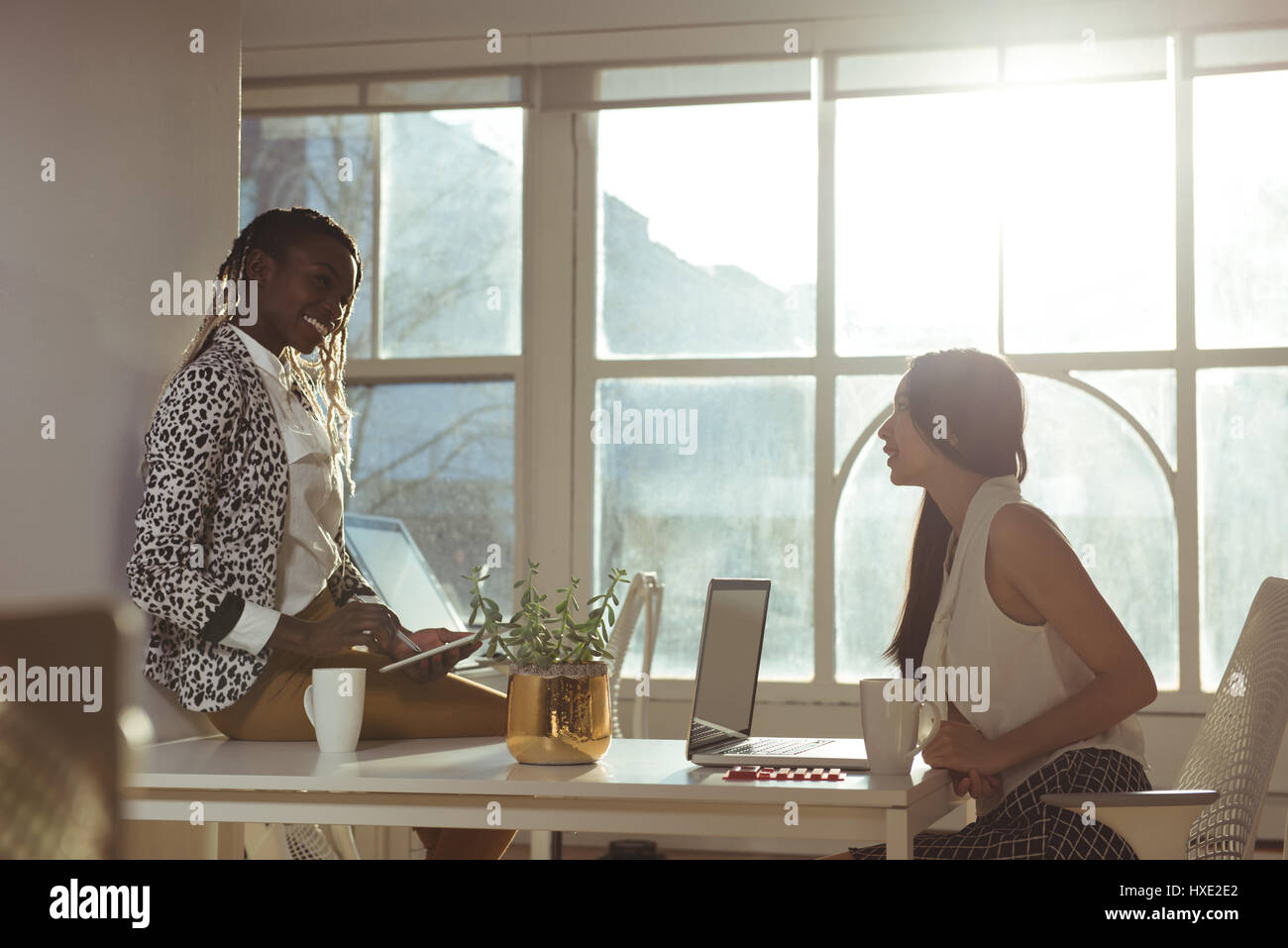 Female executives having a conversation at desk in the office Stock ...
