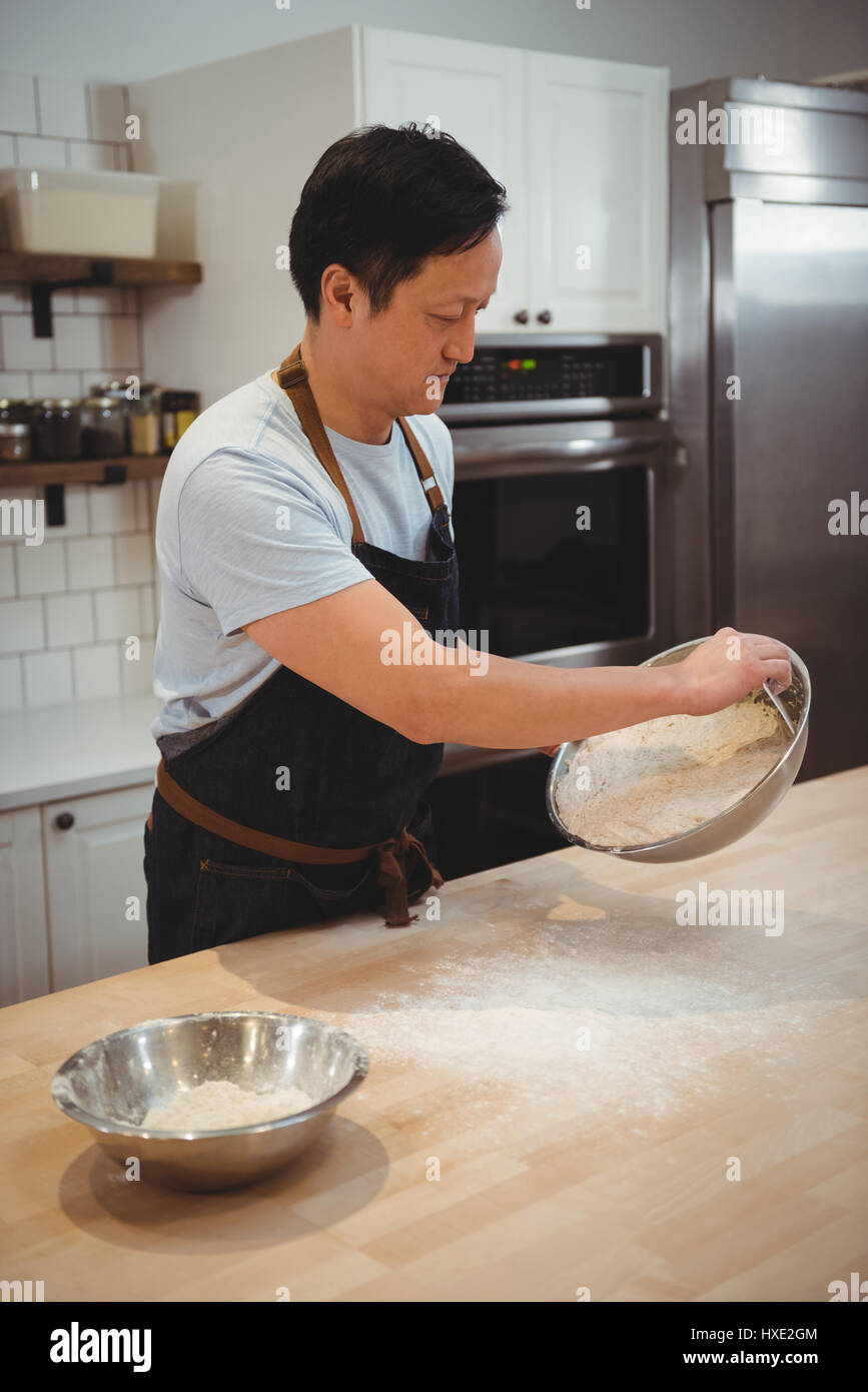 Male chef mixing flour in bowl at counter in professional kitchen Stock ...