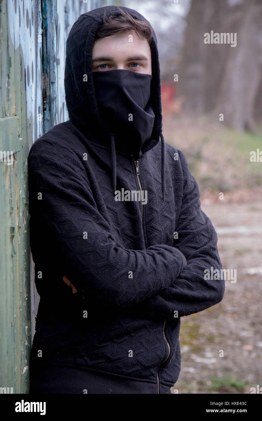 Teenage boy with his face hidden by a mask Stock Photo - Alamy
