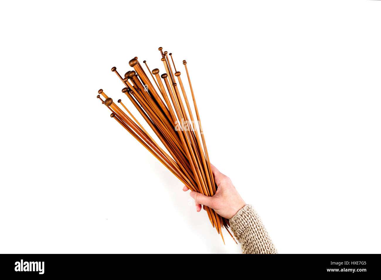 Woman hand holding a lot wooden knitting needles on white background ...