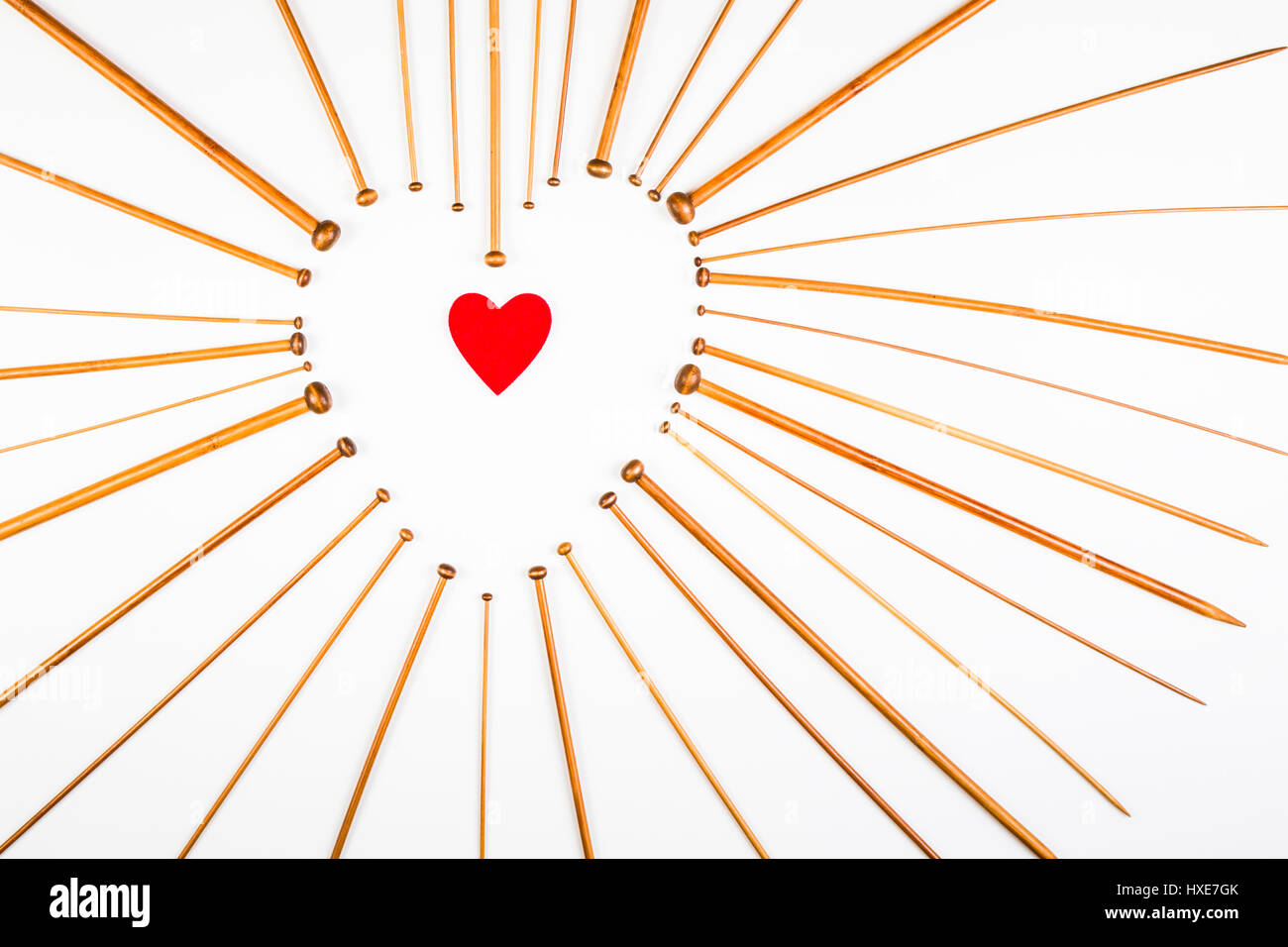 Heart symbol made of knitting needles on white background. flat lay ...