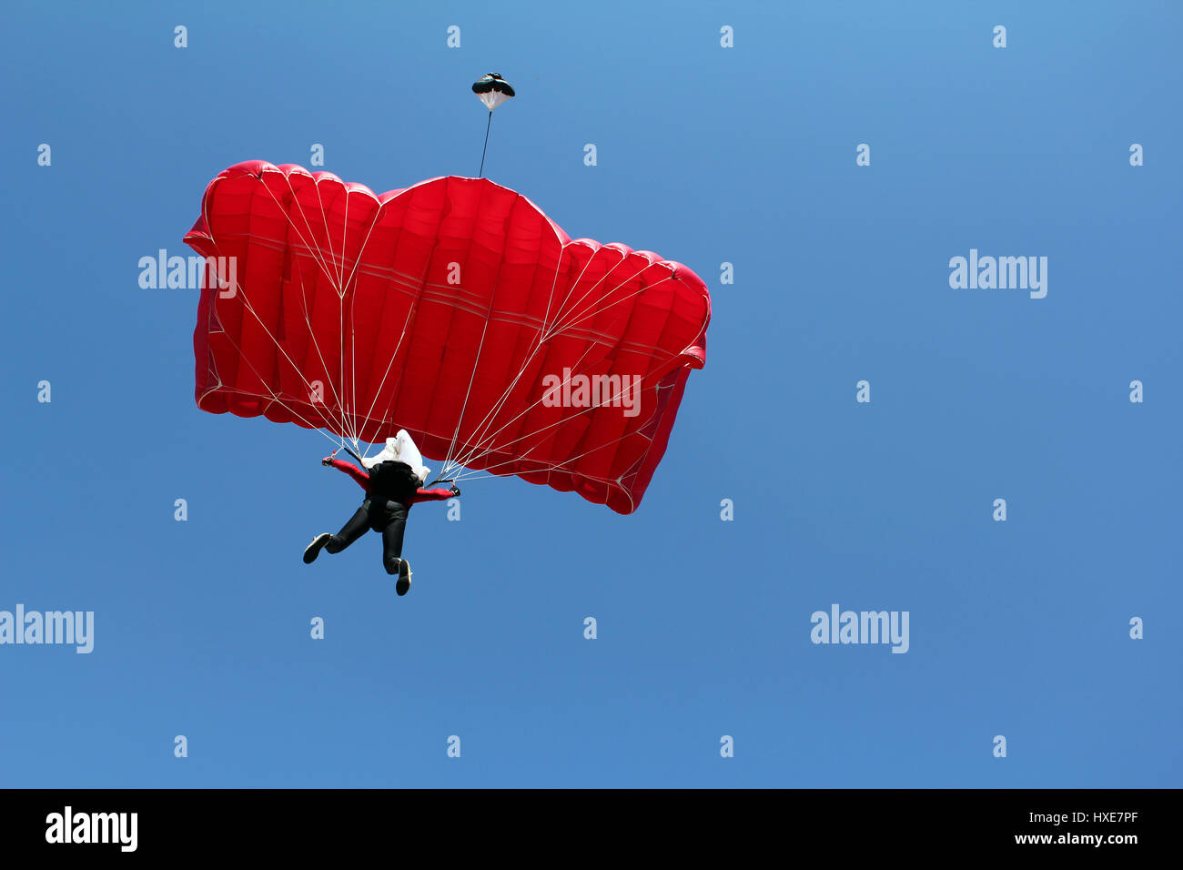 parachutist with red parachute on blue sky Stock Photo - Alamy