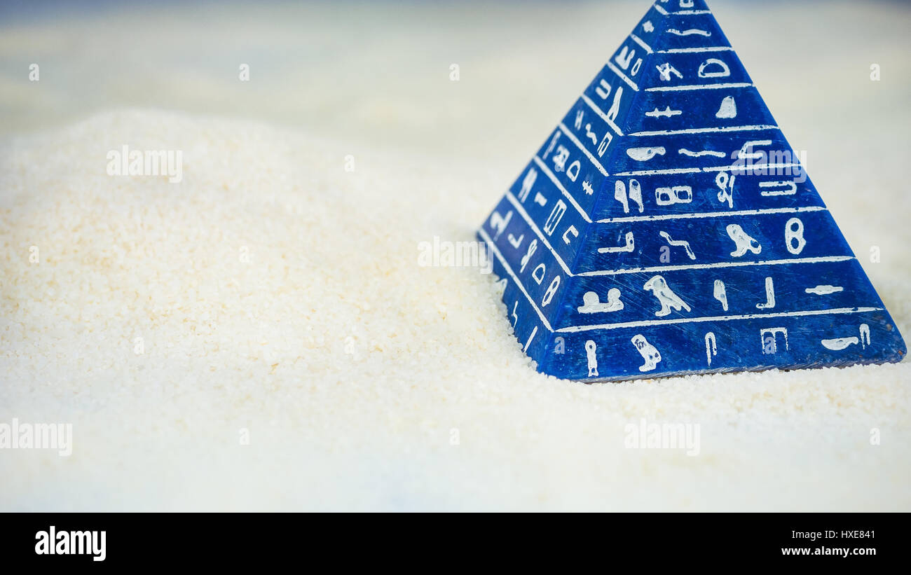Abstract blue pyramid with hieroglyph staying on sand Stock Photo - Alamy