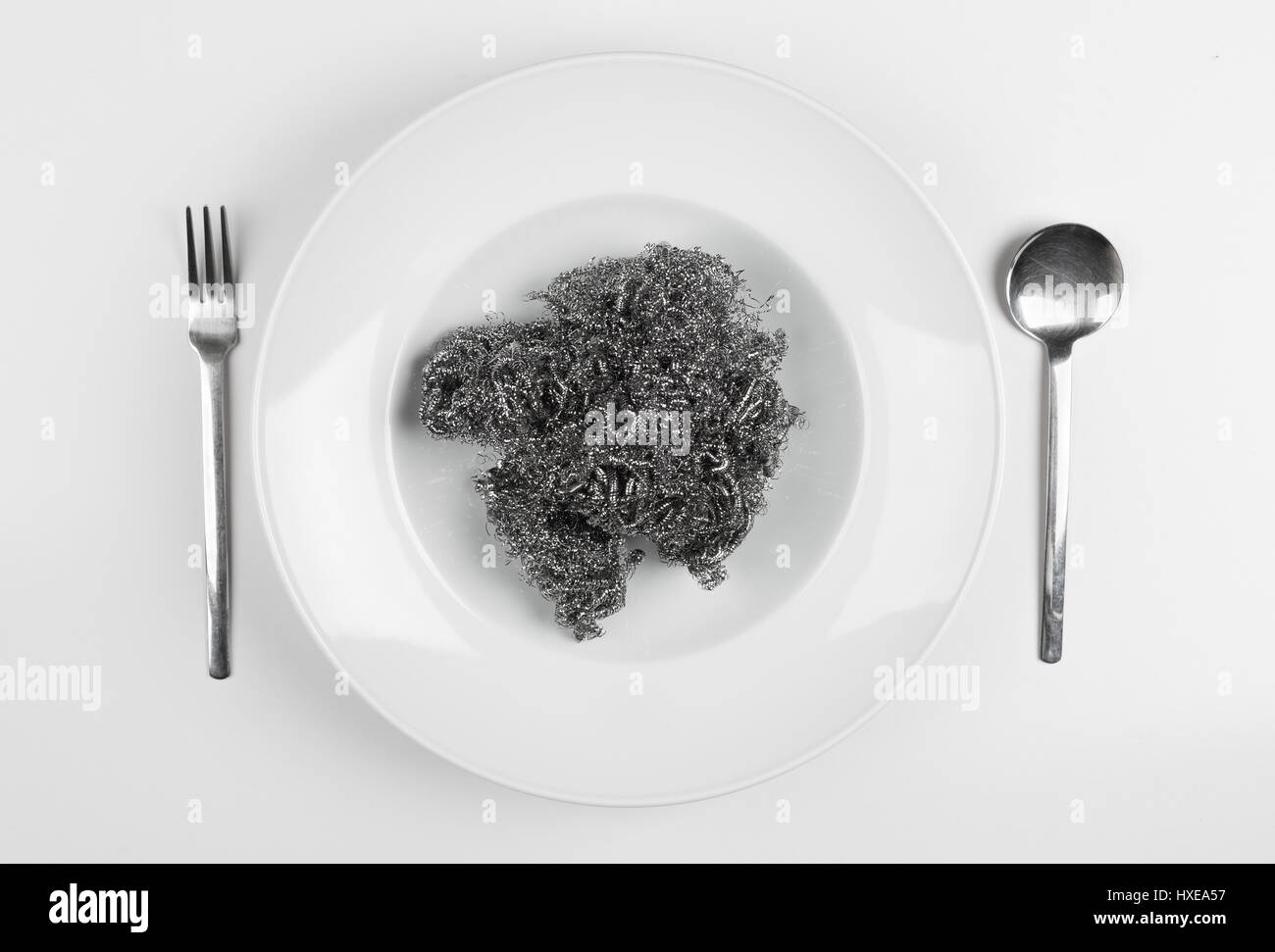 Steel spaghetti on plate with fork and spoon Stock Photo - Alamy