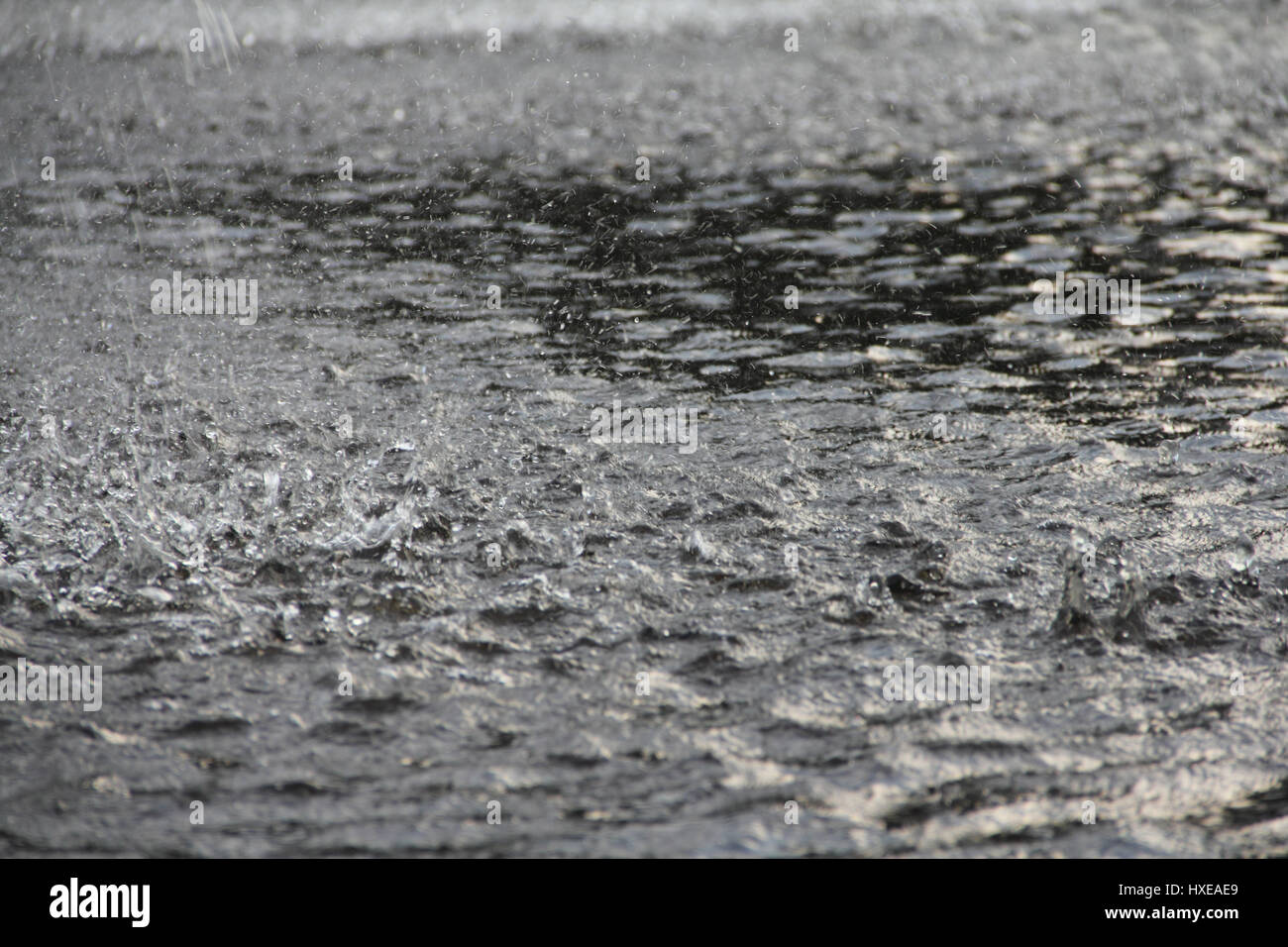 Heavy rain on ground, water drops splashing on water surface Stock ...