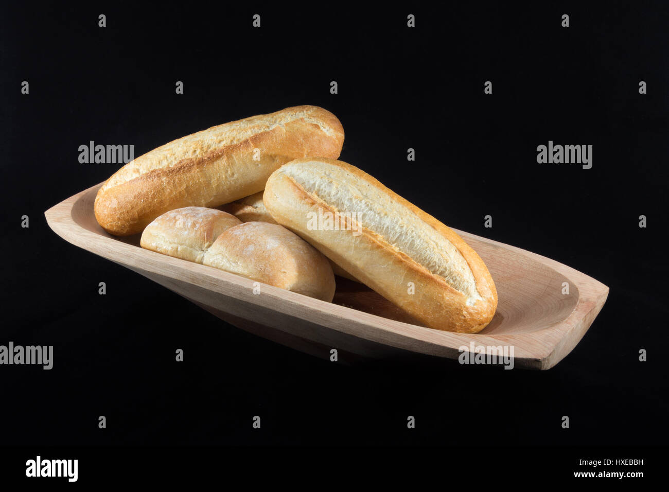 Mini French Baguettes on a rectangular wood bowl with black background ...