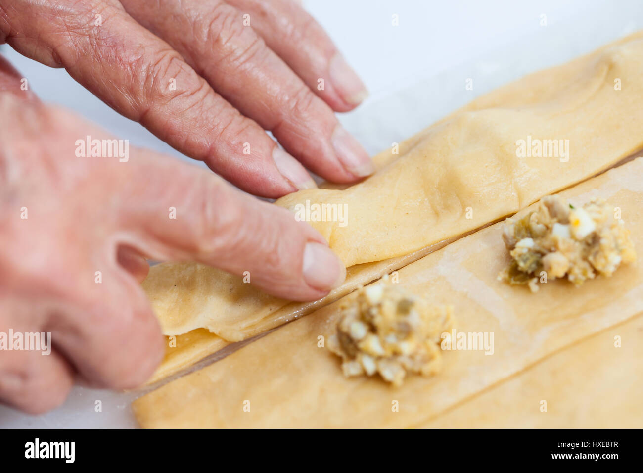 Ravioli Preparation : Placing the upper dough strip to seal the ravioli ...