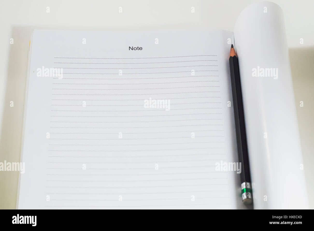 A black pencil on a notebook Stock Photo - Alamy