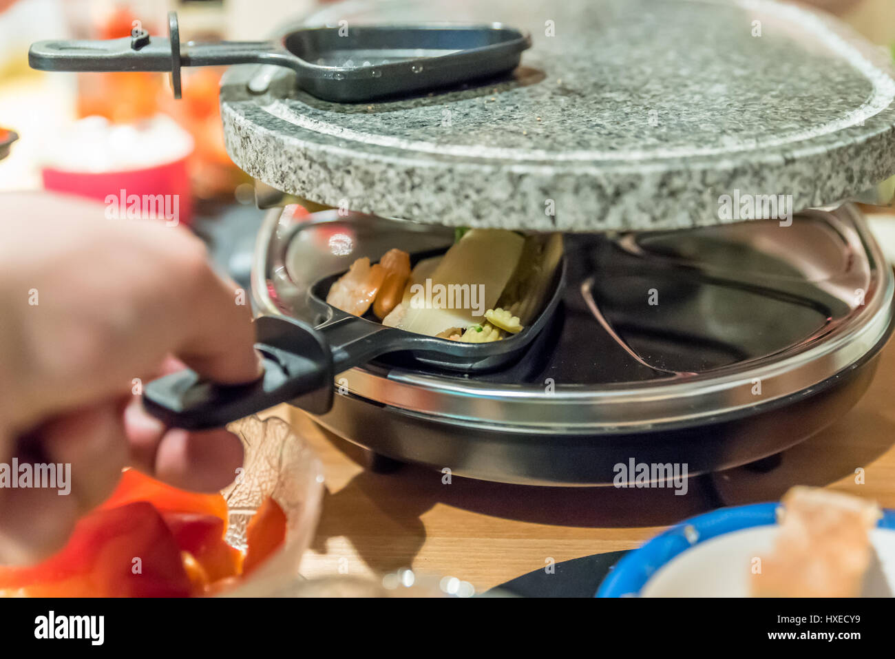 View of Family table for cooking on Raclette Stock Photo - Alamy