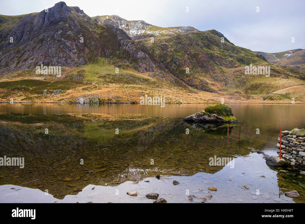 Y Garn mountain reflected in calm waters of Llyn Idwal lake in ...