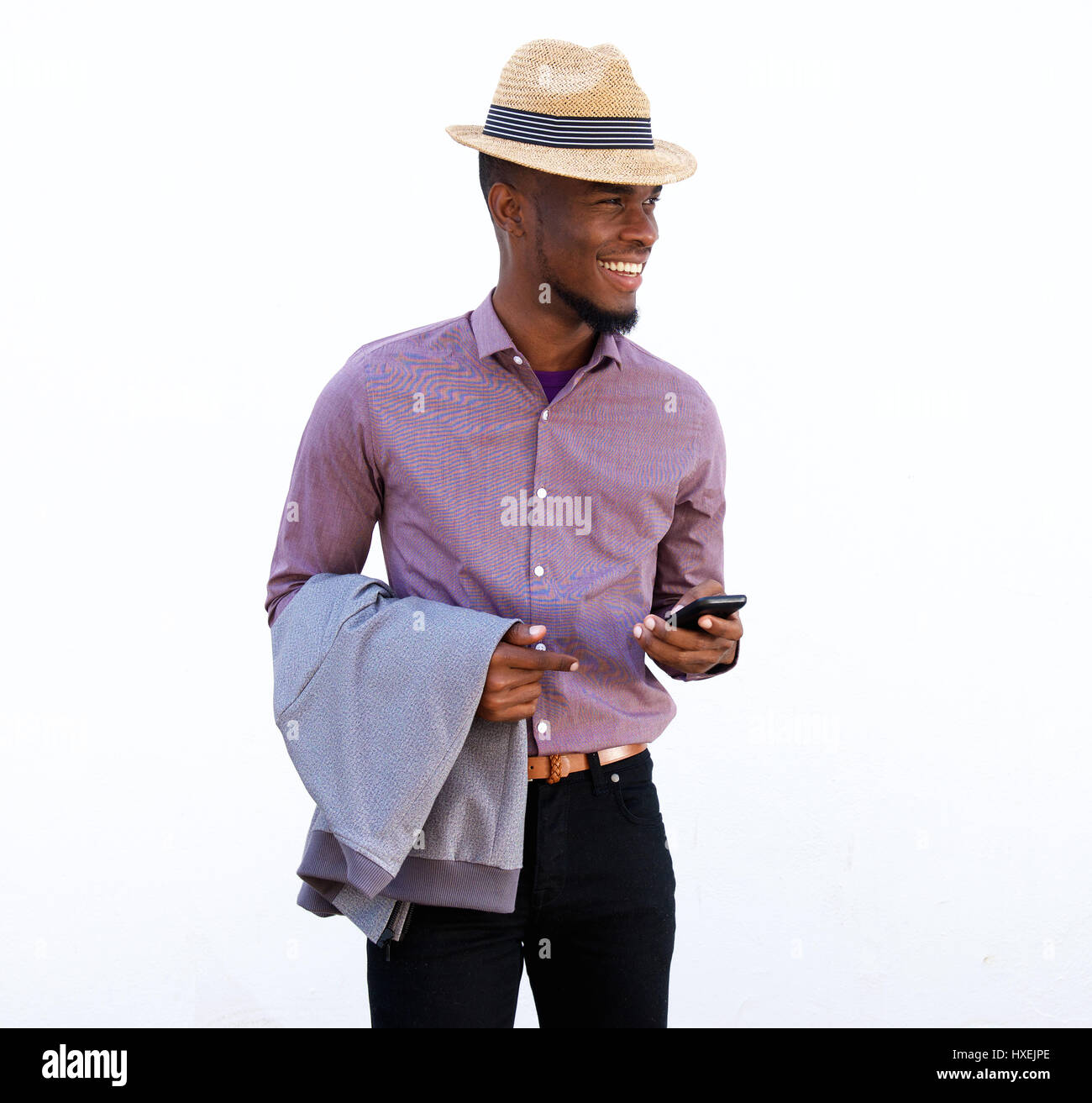 Portrait of a stylish young african guy with cell phone standing ...