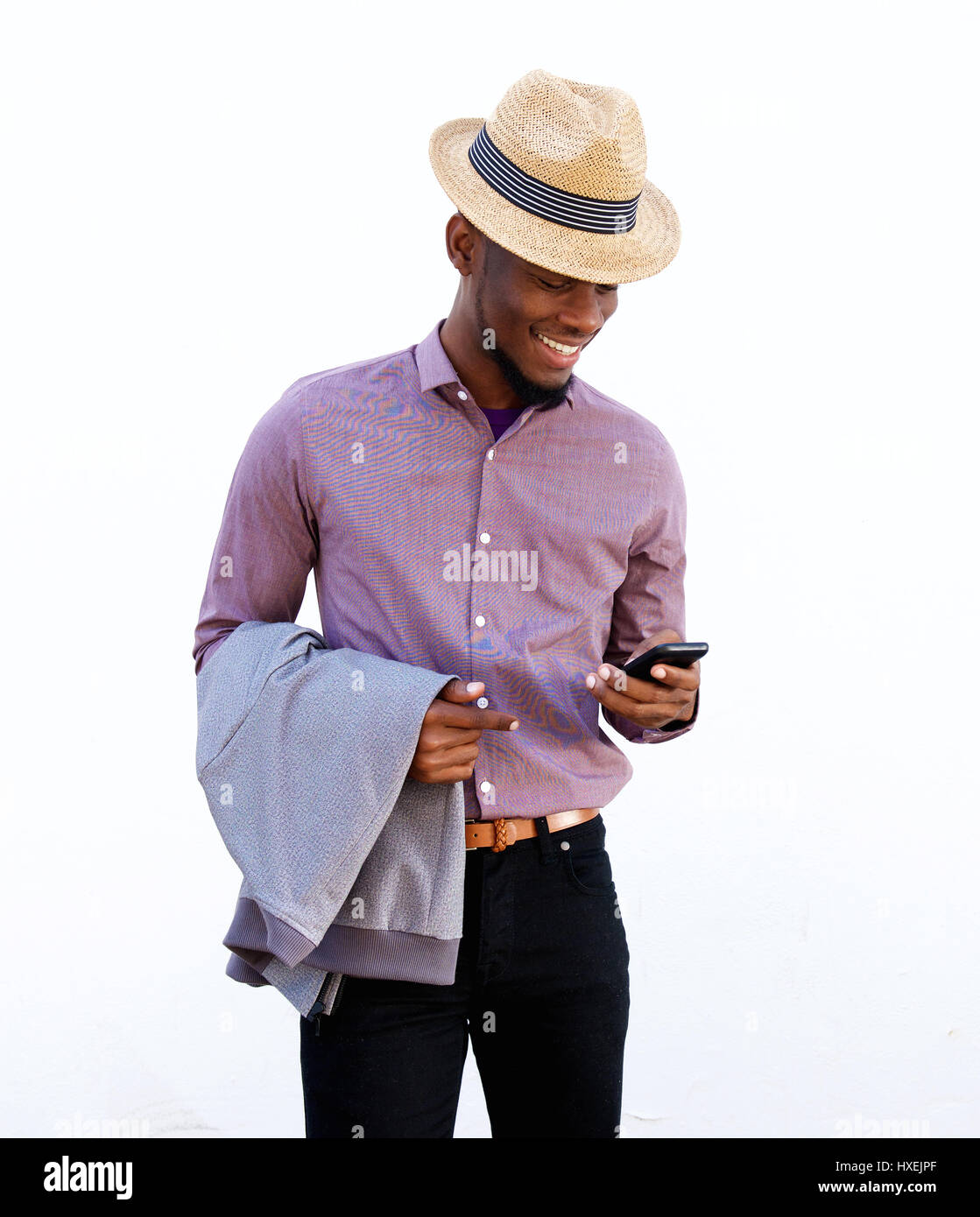 Portrait of a young black guy sending text message on mobile phone ...