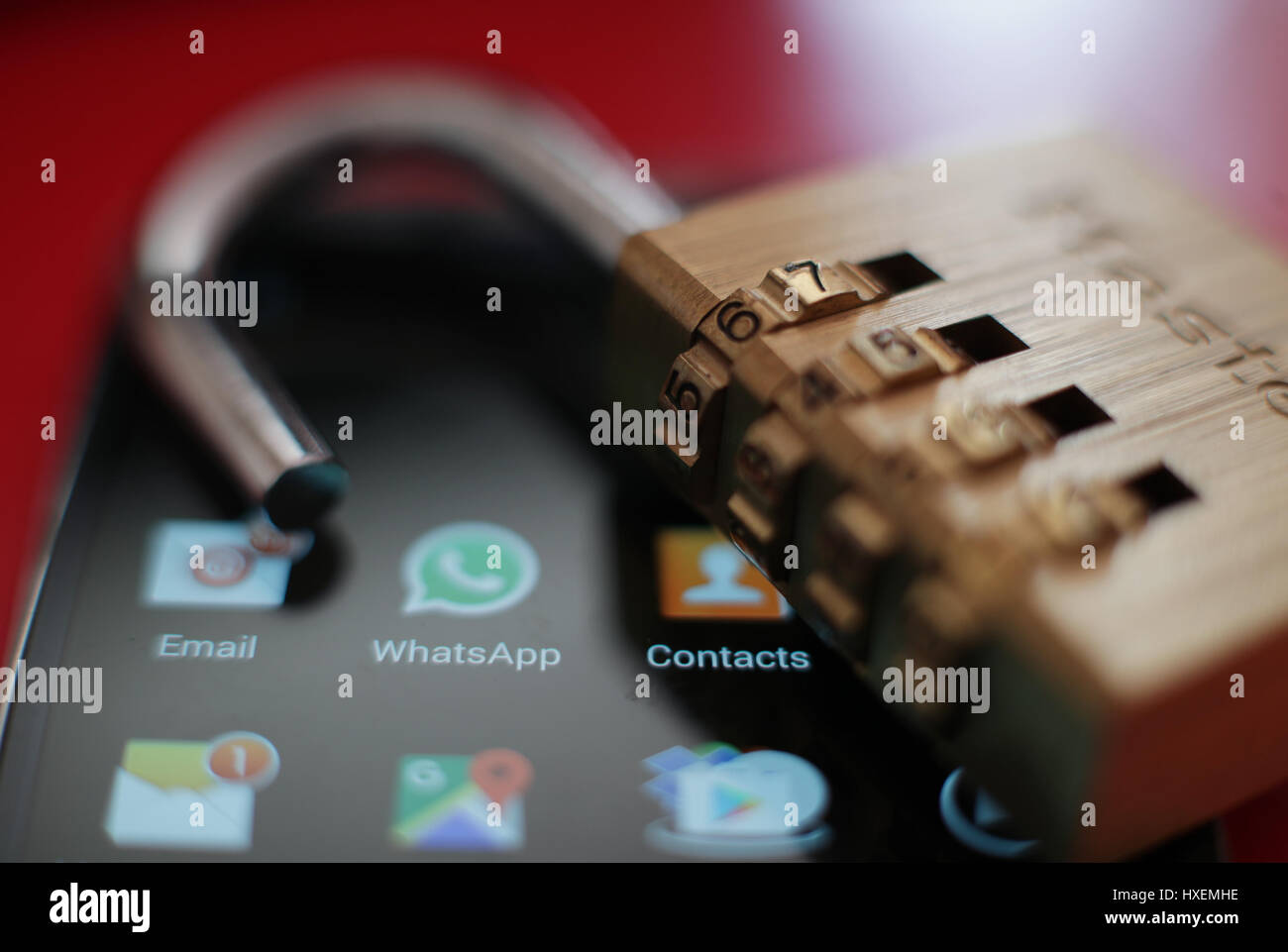 A combination padlock is placed next to the WhatsApp icon on the screen ...