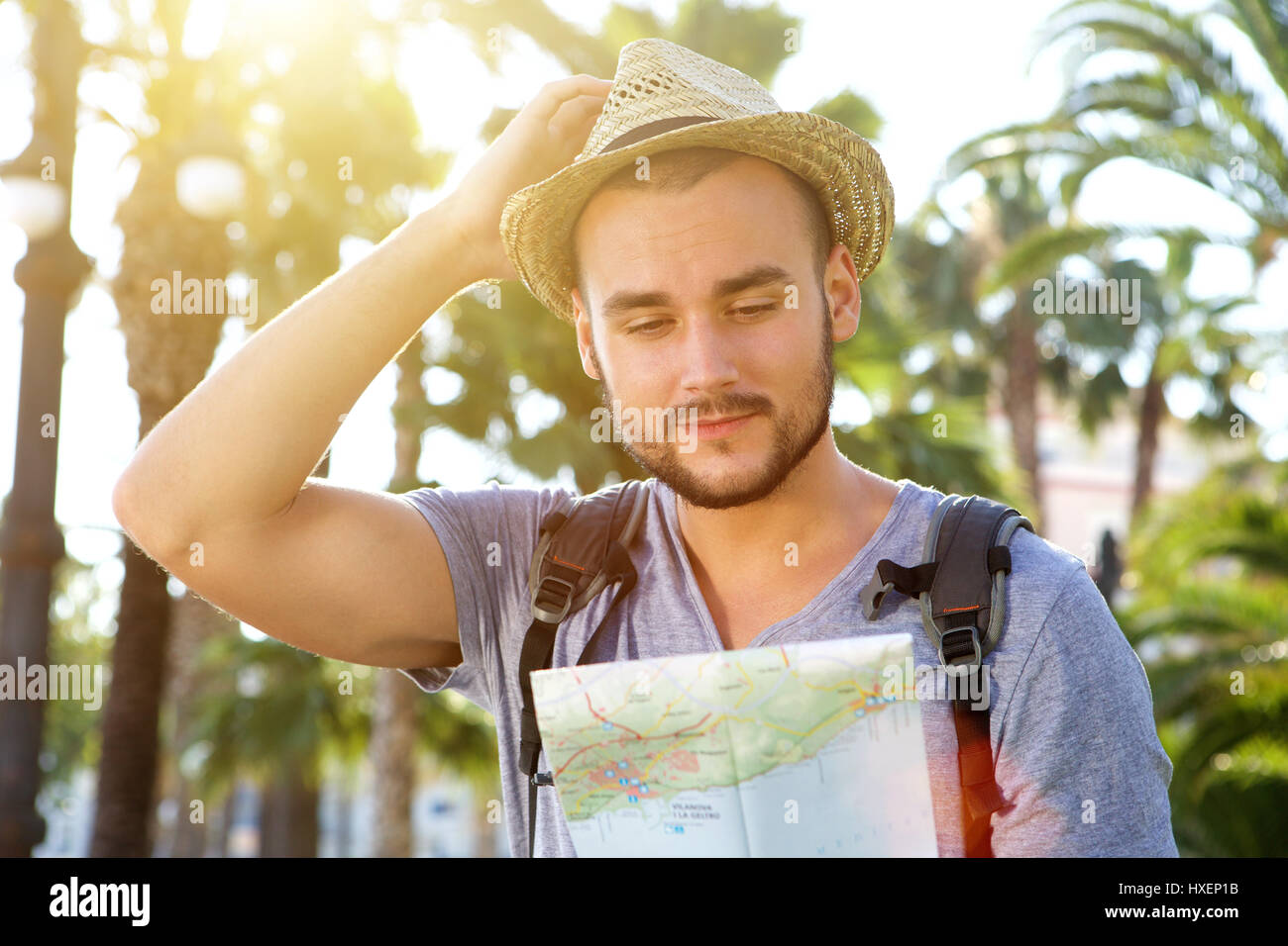 Portrait of a traveling man reading map outside Stock Photo - Alamy