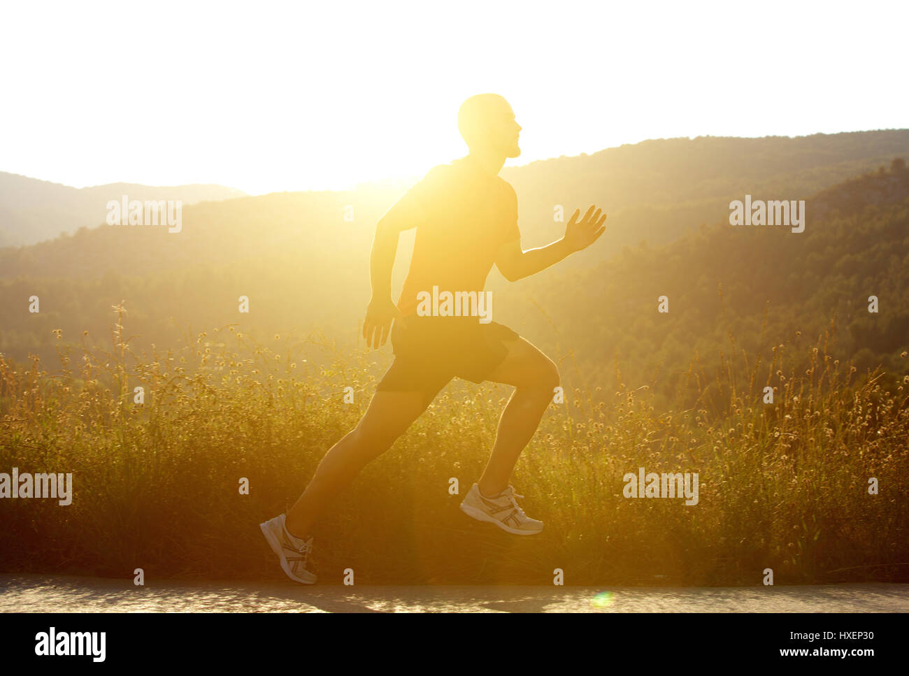 Side portrait of a man running outside with sunset Stock Photo - Alamy