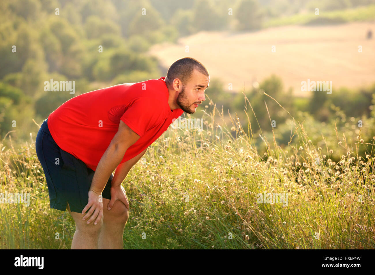 Tired sports man relaxing after running exercise workout Stock Photo ...