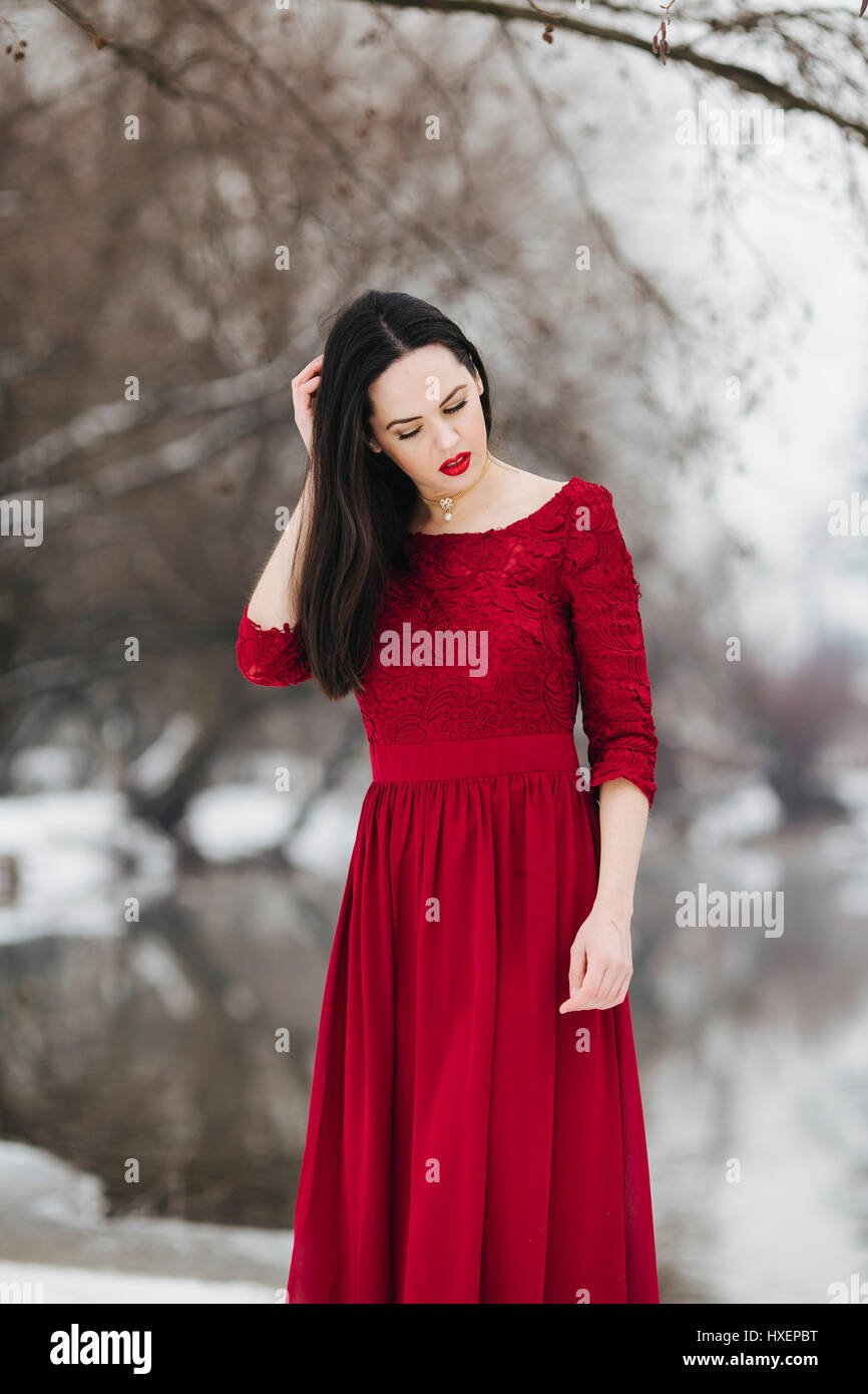 Women in red dress standing in the snow Stock Photo - Alamy