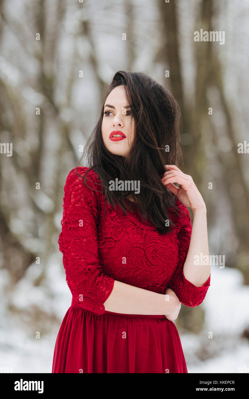 Women in red dress standing in the snow Stock Photo - Alamy