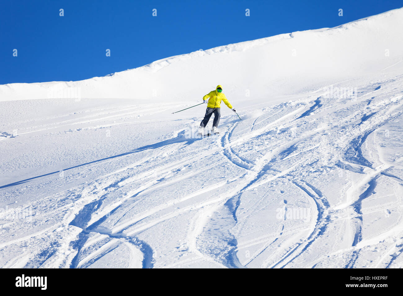 Portrait of male skier running downhill on slope at sunny day Stock ...