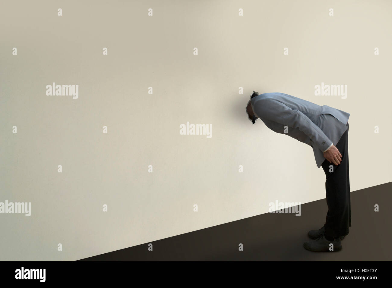 Business man looking through a hole in the wall Stock Photo - Alamy