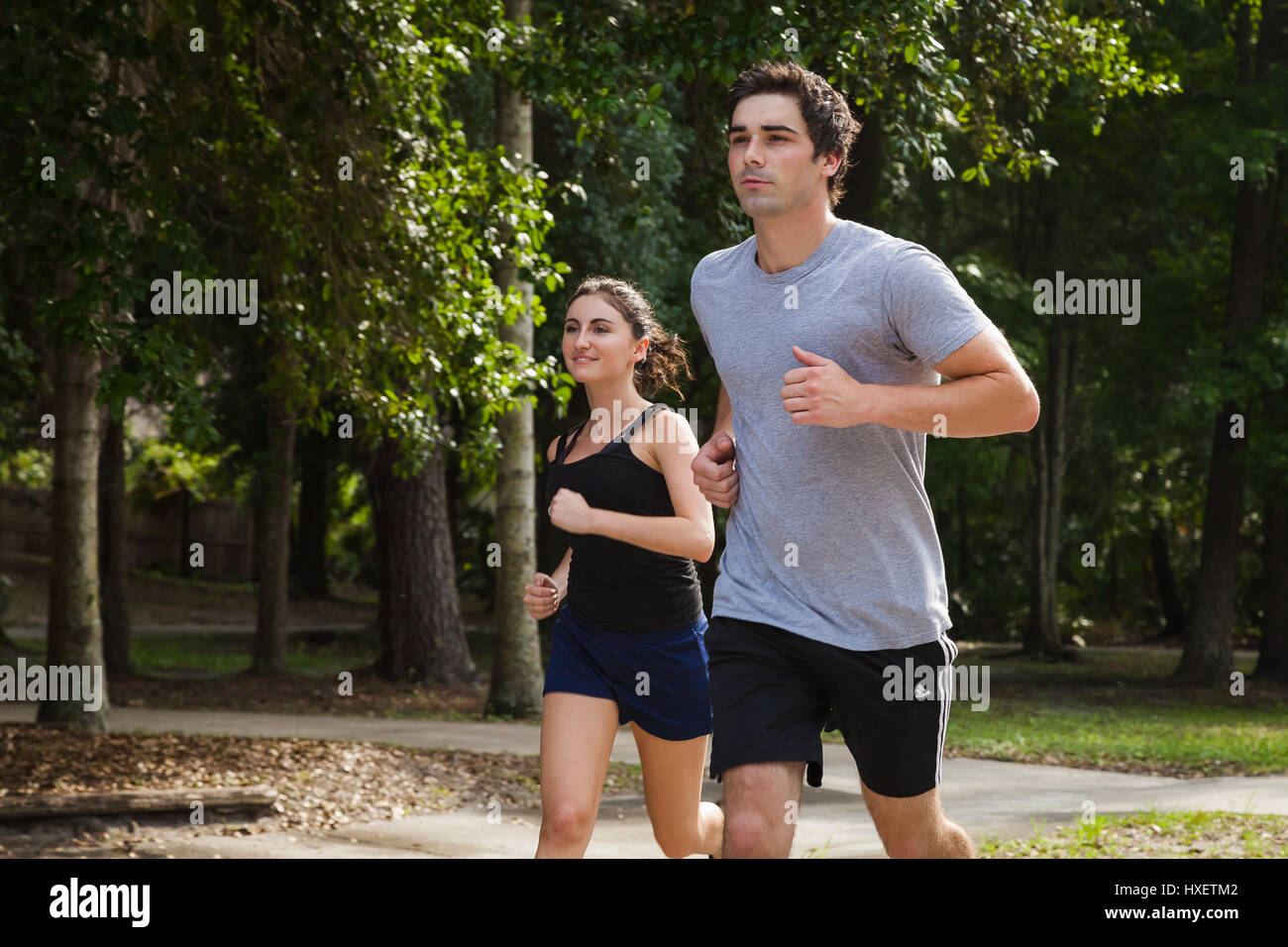 Active Couple running in Late Afternoon Stock Photo - Alamy