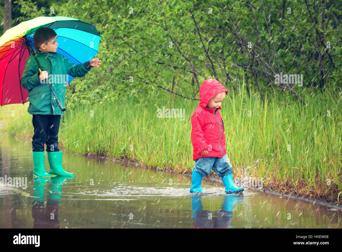 Children walking in wellies in puddle on rainy weather Stock Photo - Alamy