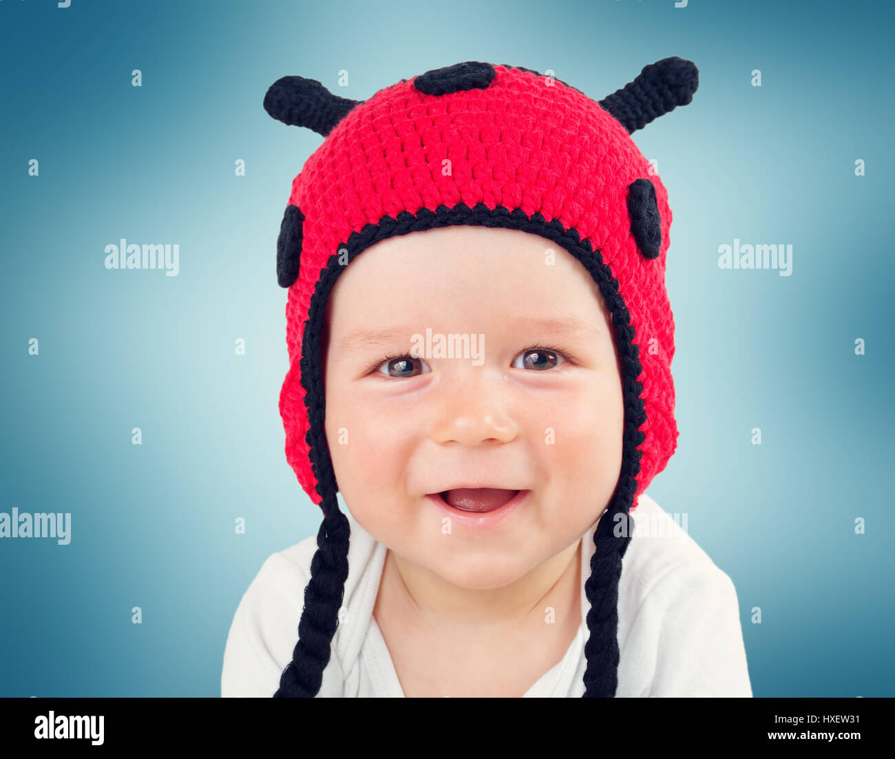 Cute baby lying in the bed on white blanket in ladybug hat Stock Photo ...