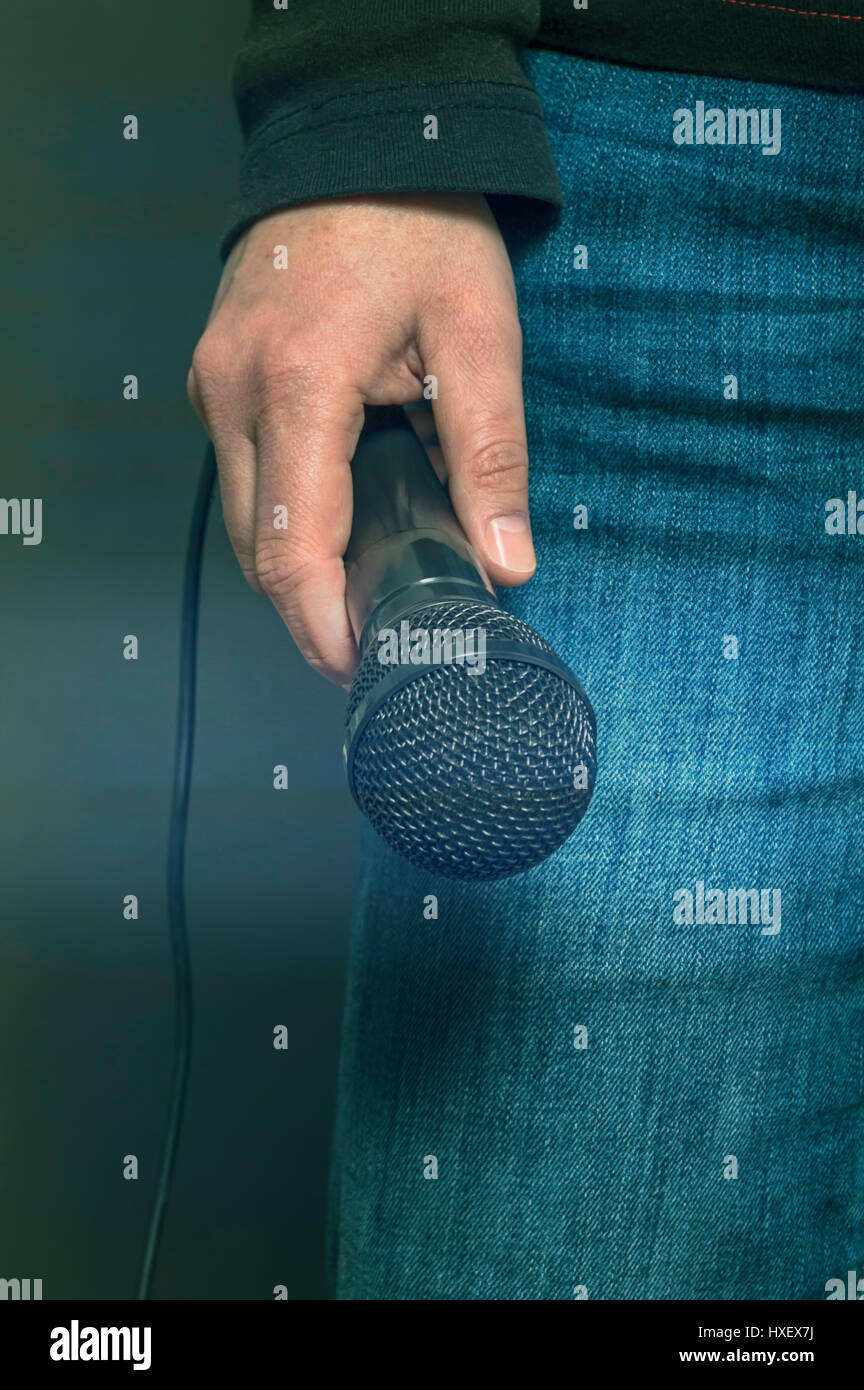 Young singer in jeans with dynamic microphone Stock Photo - Alamy
