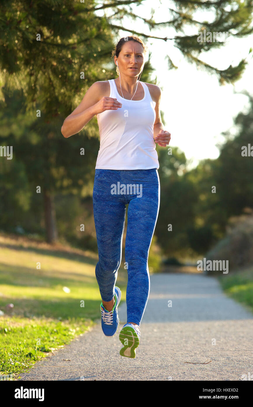 Full body portrait of an active woman running in park Stock Photo - Alamy