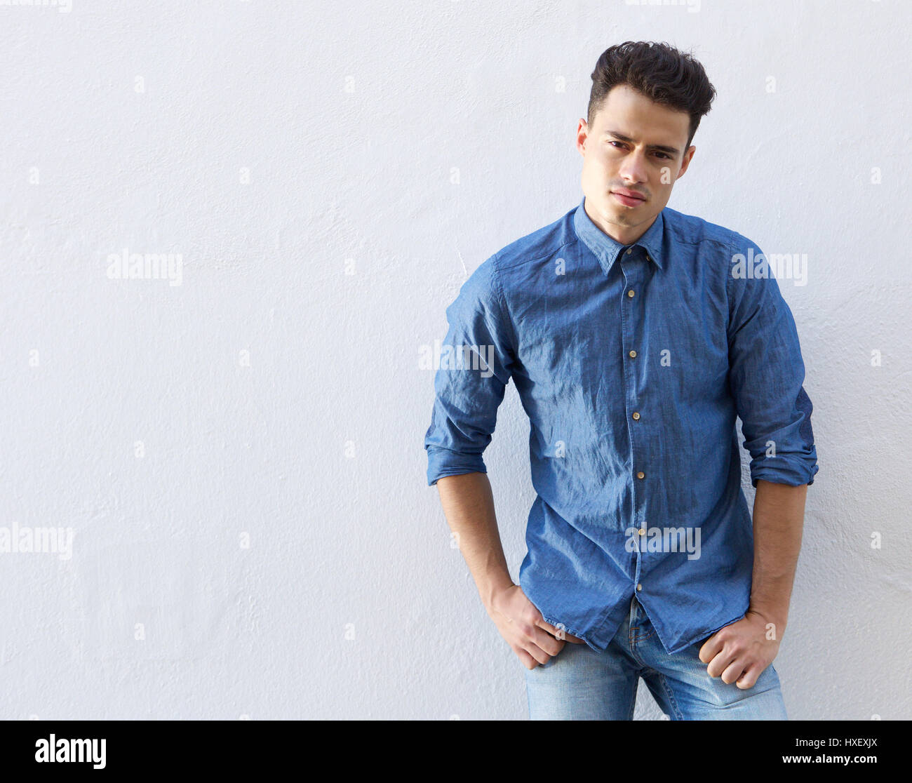 Portrait of a good looking young man standing against white background ...