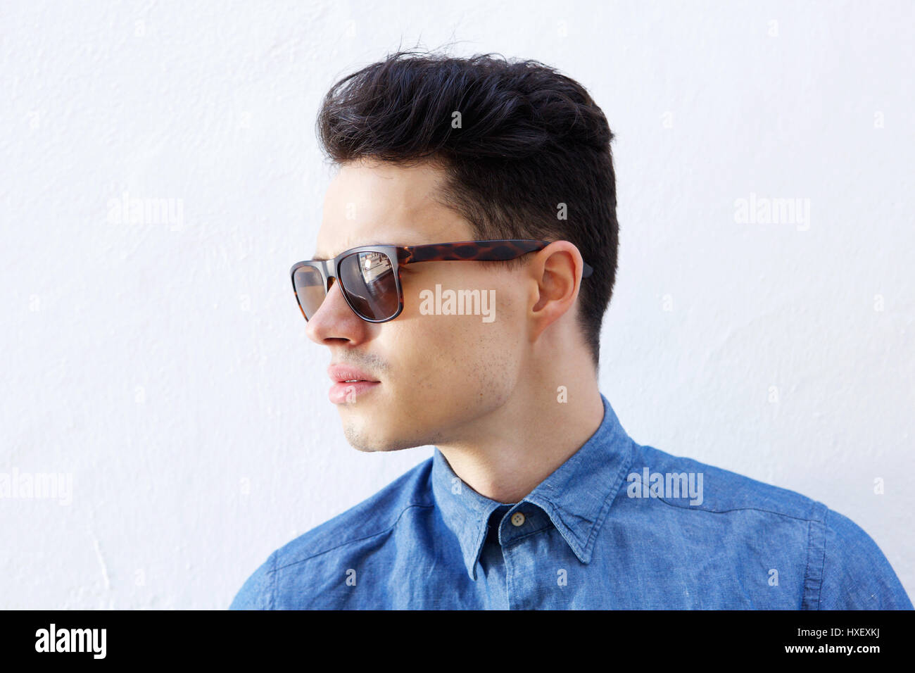 Close up portrait of a male fashion model posing with sunglasses on ...