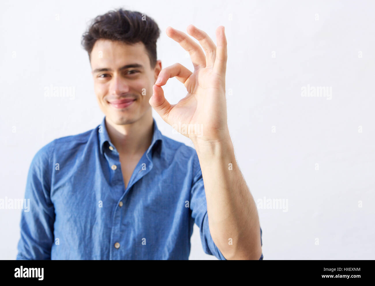Portrait of a good looking young man with ok hand sign Stock Photo - Alamy