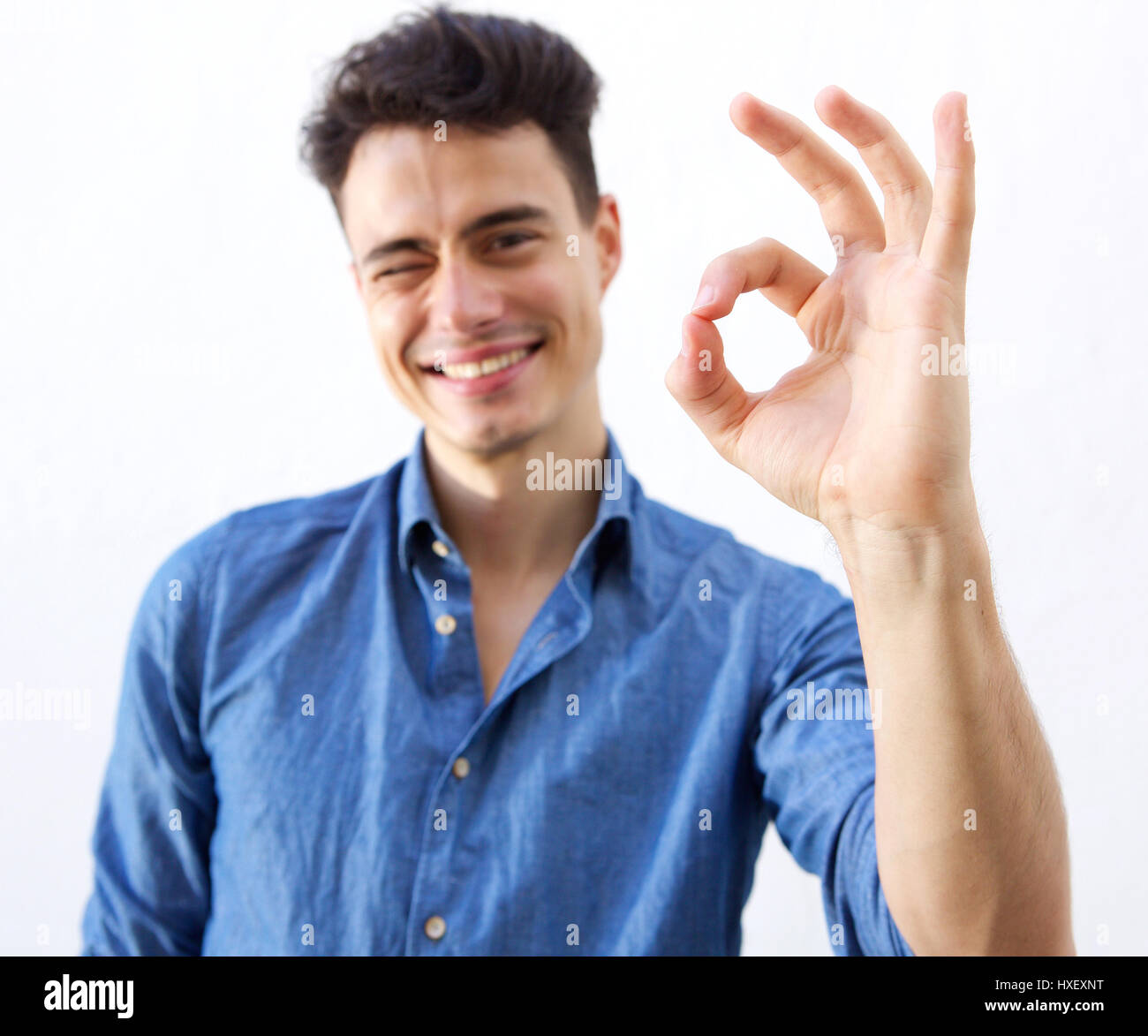 Portrait of a confident young man with ok hand sign Stock Photo - Alamy