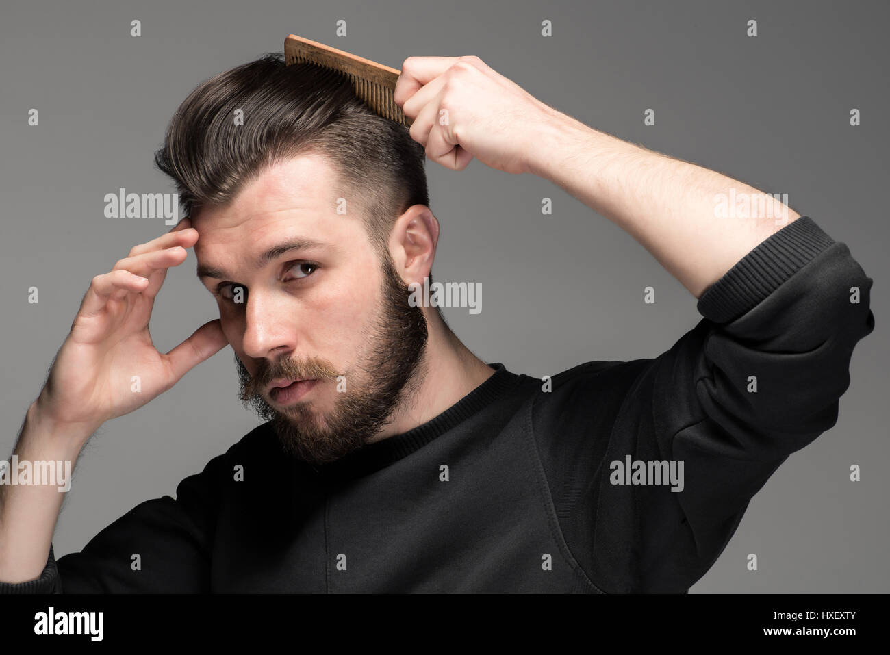 Portrait of stylish handsome young man combing his hair Stock Photo - Alamy