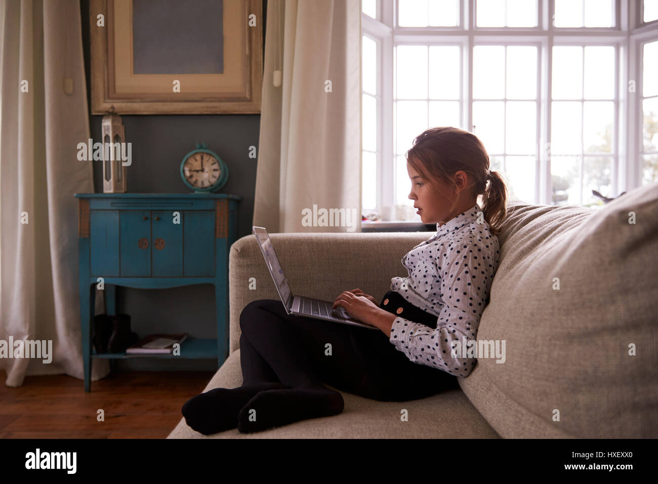 Girl Sitting On Sofa At Home Using Laptop Computer Stock Photo - Alamy