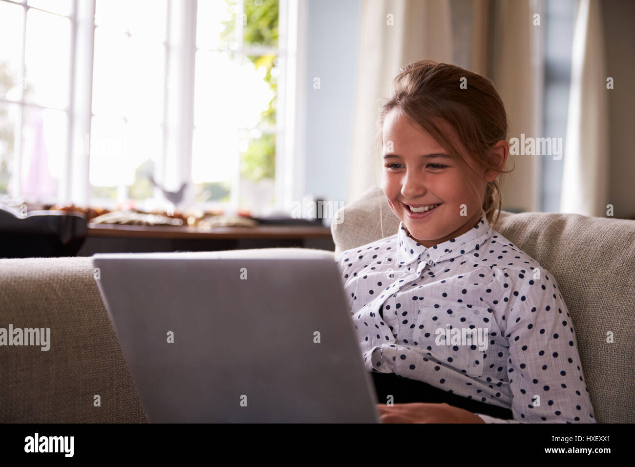 Girl Sitting On Sofa At Home Using Laptop Computer Stock Photo - Alamy