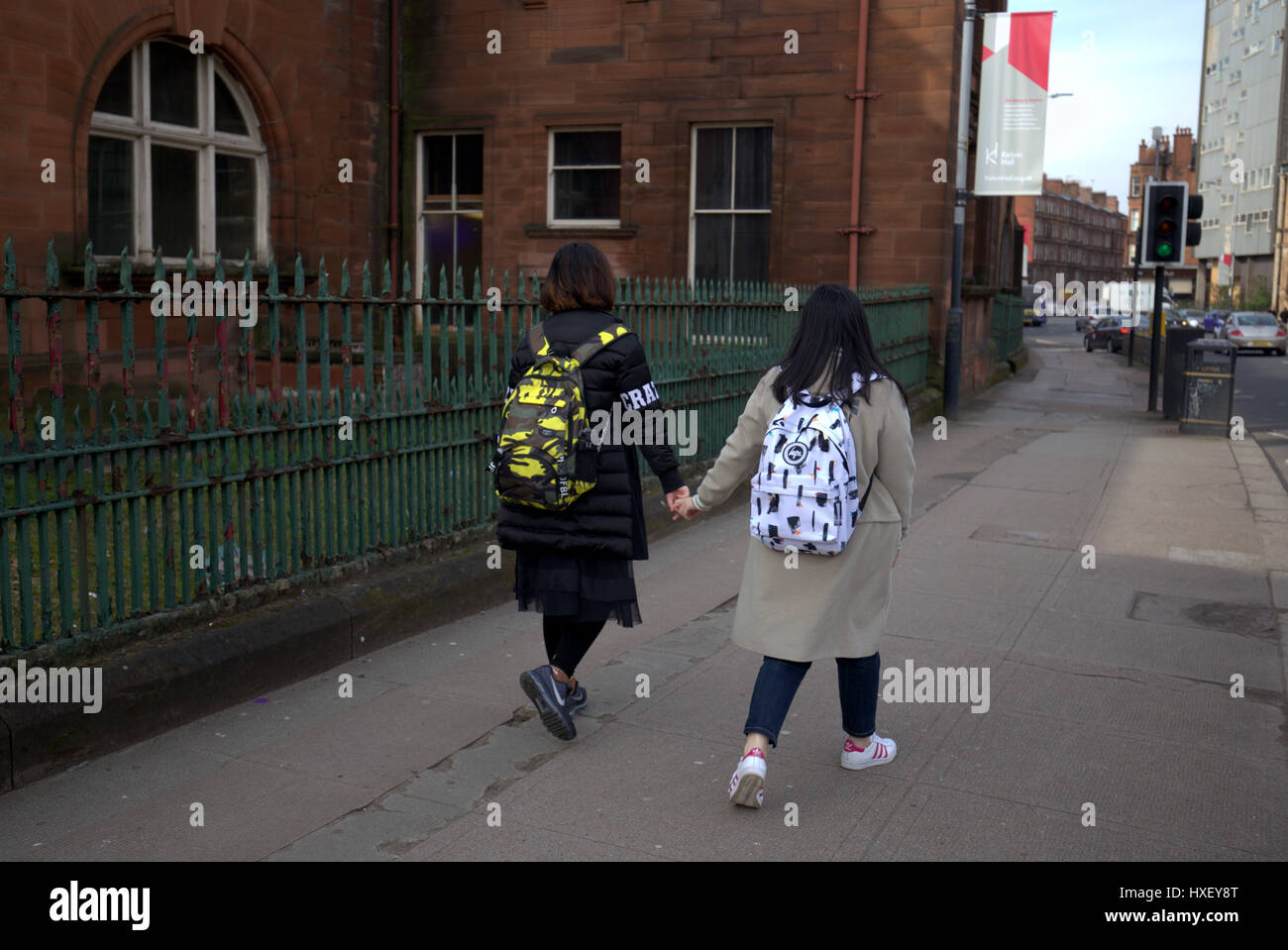 Chinese Asian students holding hands walking on street Stock Photo - Alamy
