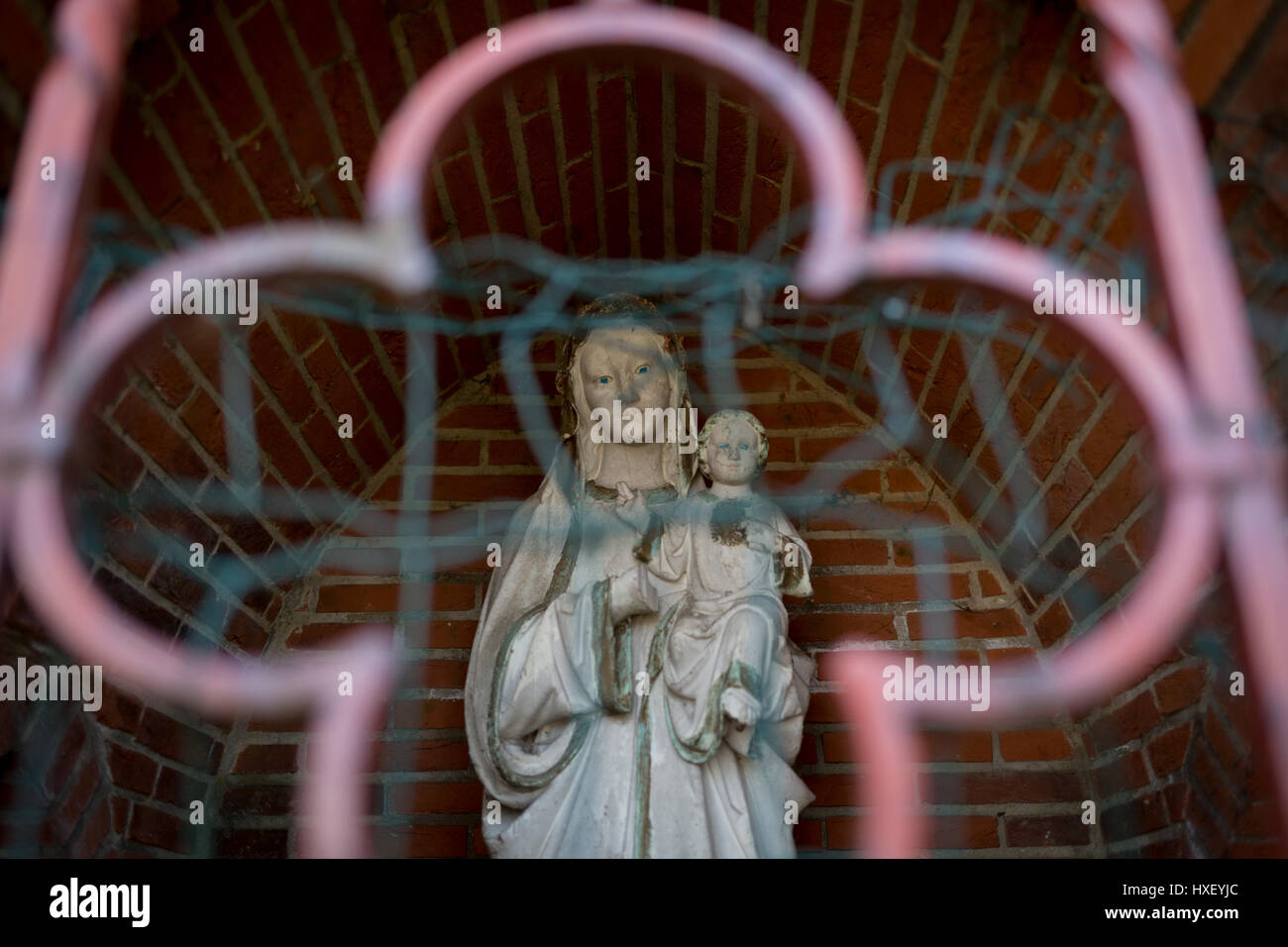 A catholic shrine showing Mary and baby Jesus, behind wire and iron ...
