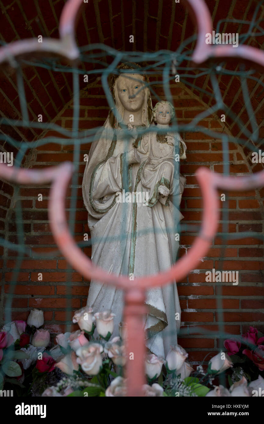 A catholic shrine showing Mary and baby Jesus, behind wire and iron ...