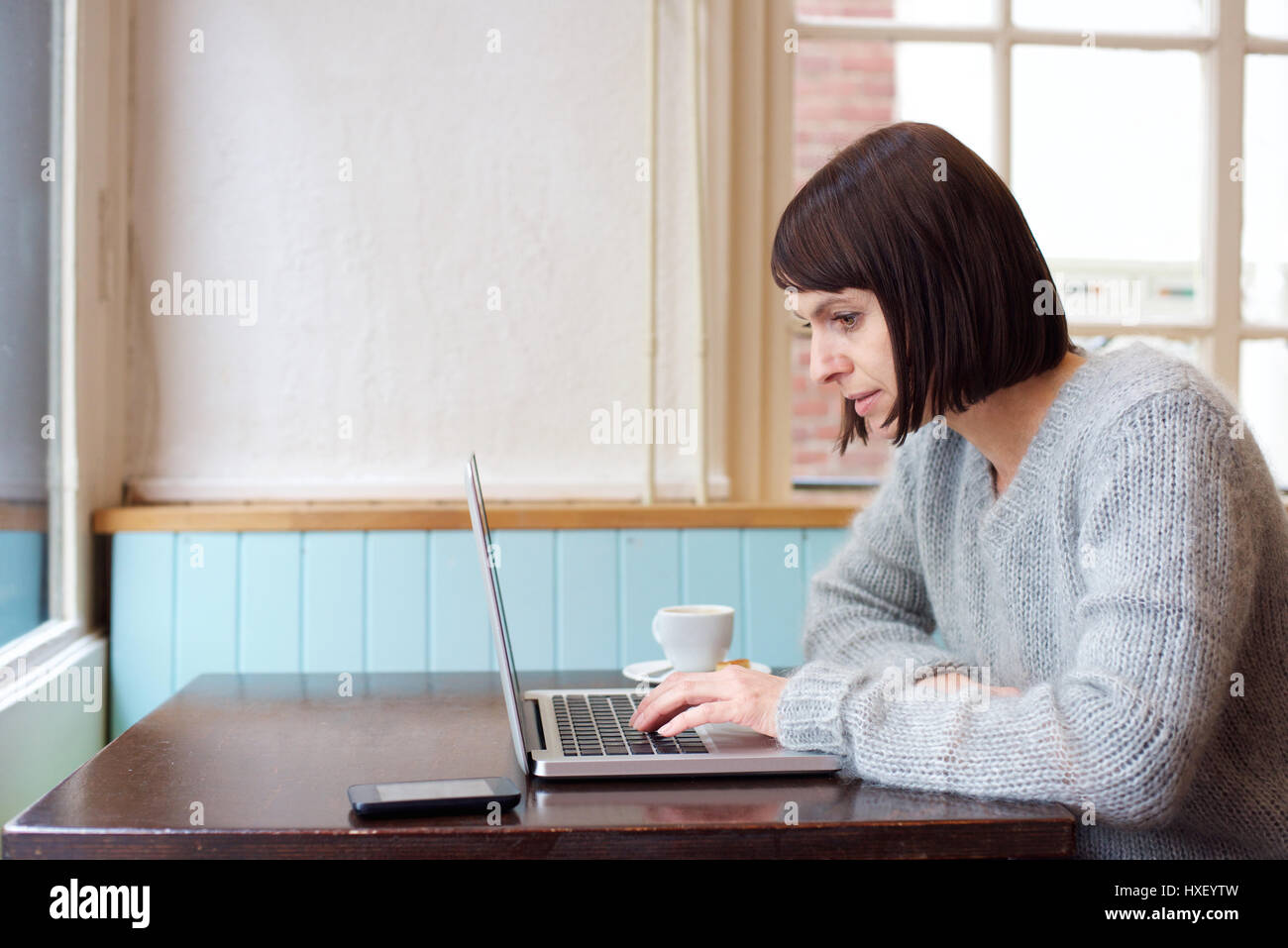 Side view portrait woman sitting at table working with laptop Stock ...