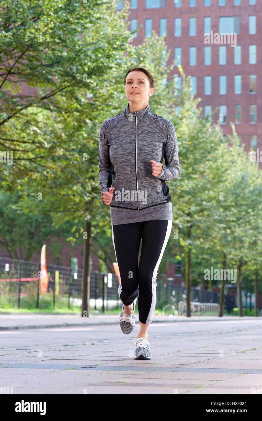 Active woman running outside in the city Stock Photo - Alamy