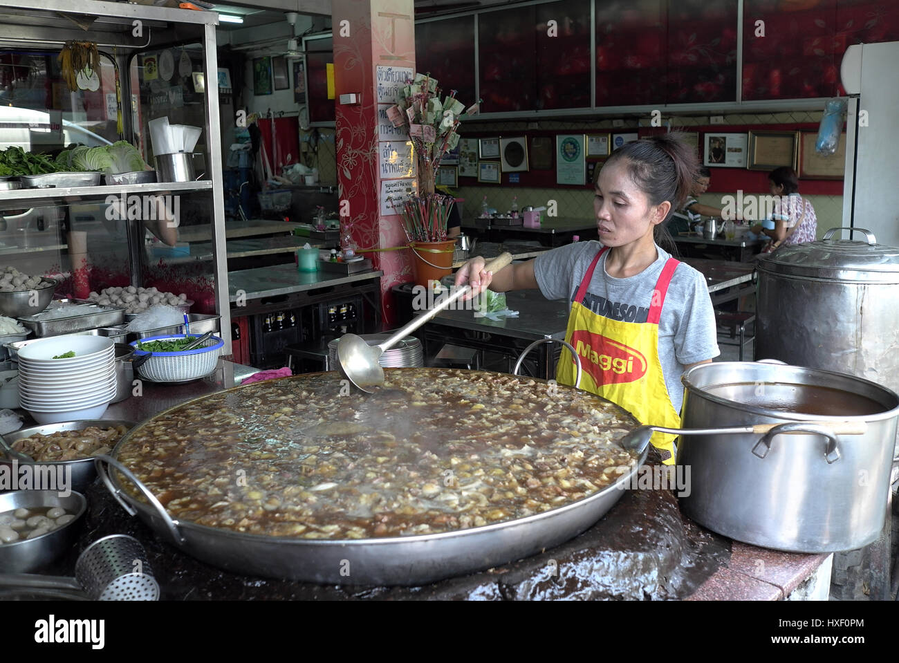 Thai lady cooking a big pot of soup at a local restaurant in Bangkok ...