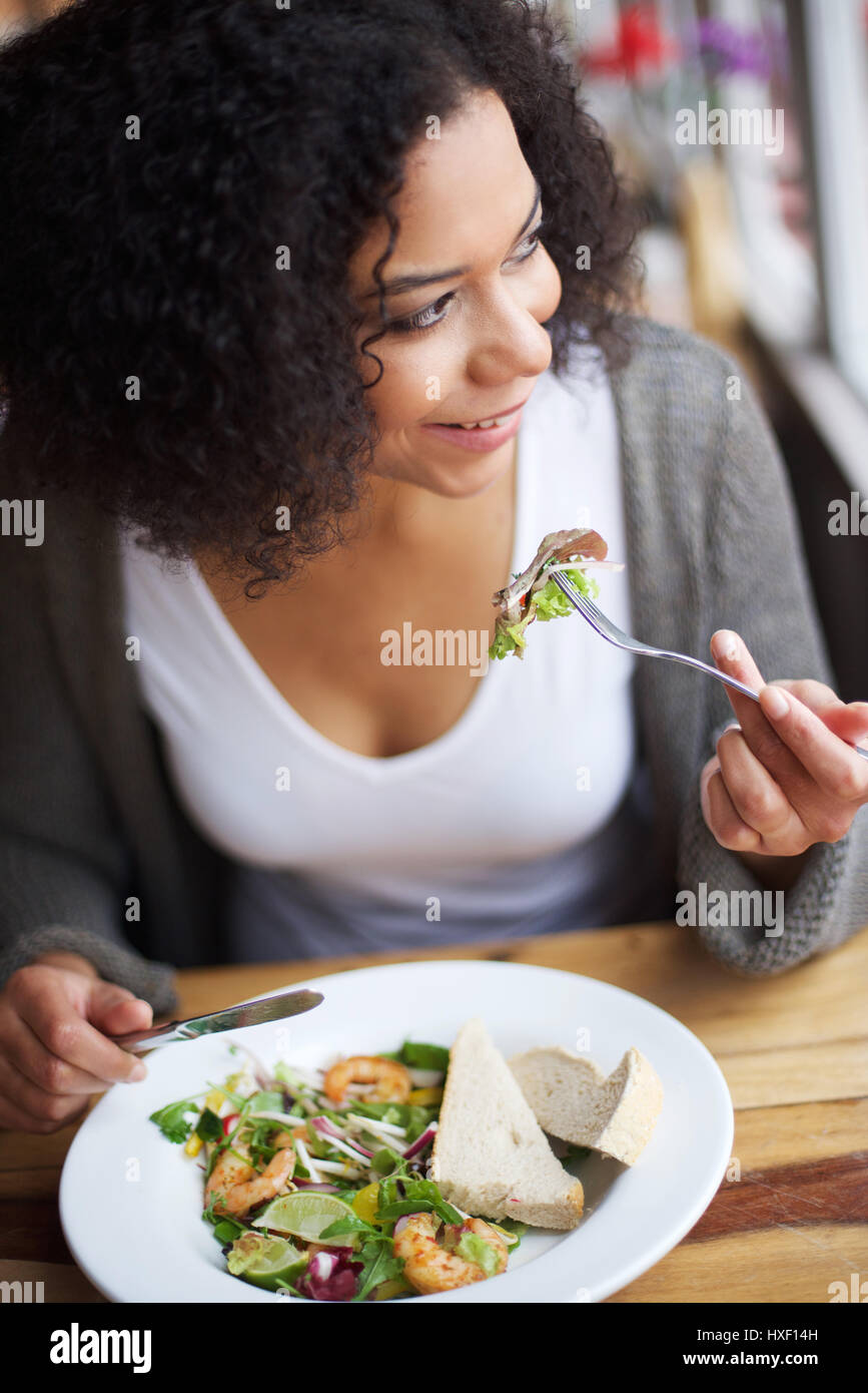 Portrait of a smiling african american woman eating in restaurant Stock ...