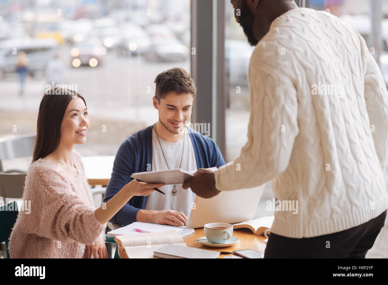 Young guy giving his notebook to a girl Stock Photo - Alamy