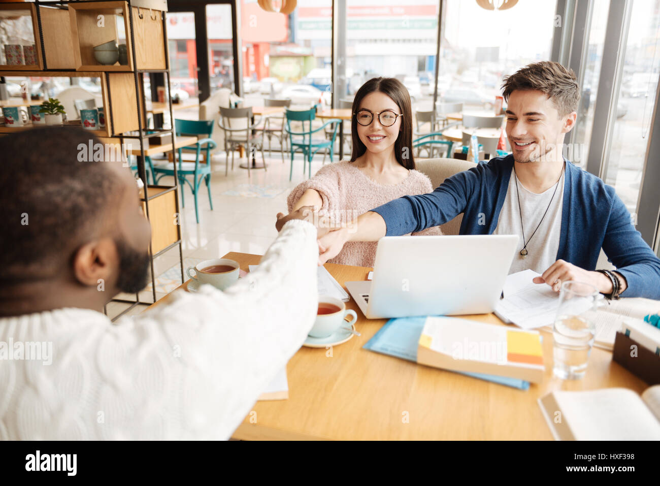 Cheerful international students shaking hands Stock Photo - Alamy