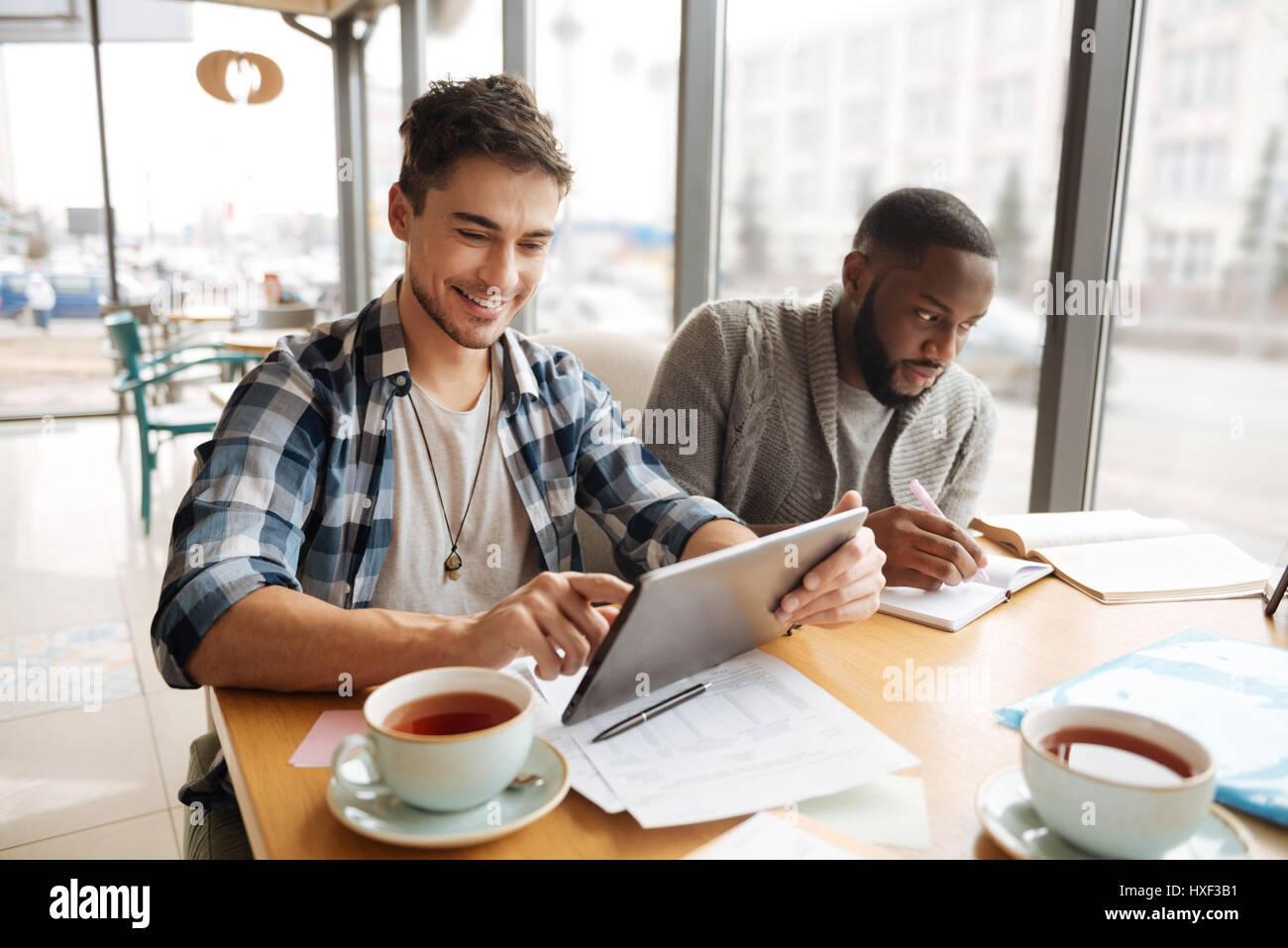 Joyful students sitting in the cafe Stock Photo - Alamy