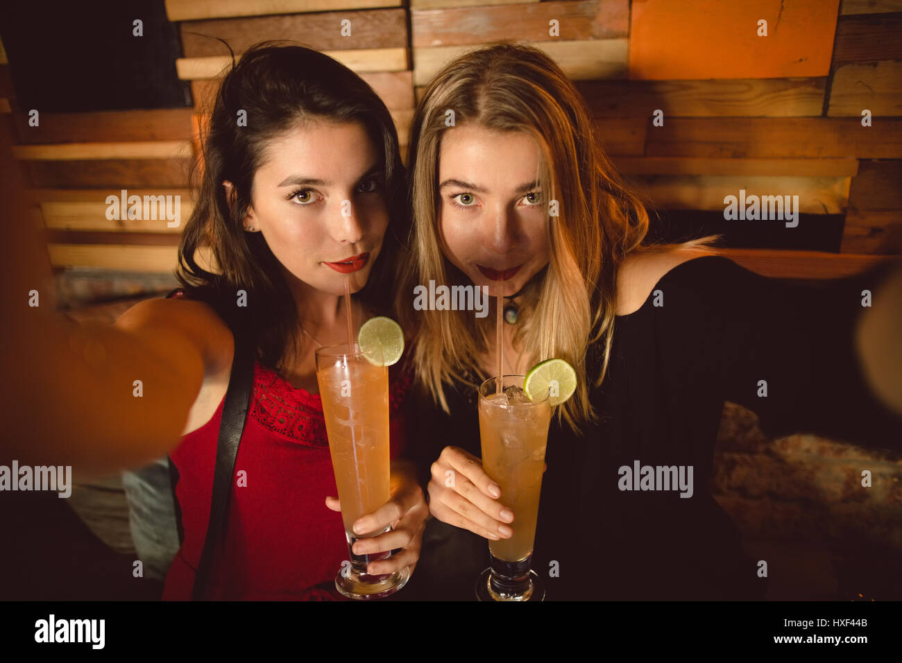 Portrait of beautiful women drinking cocktail in bar Stock Photo - Alamy