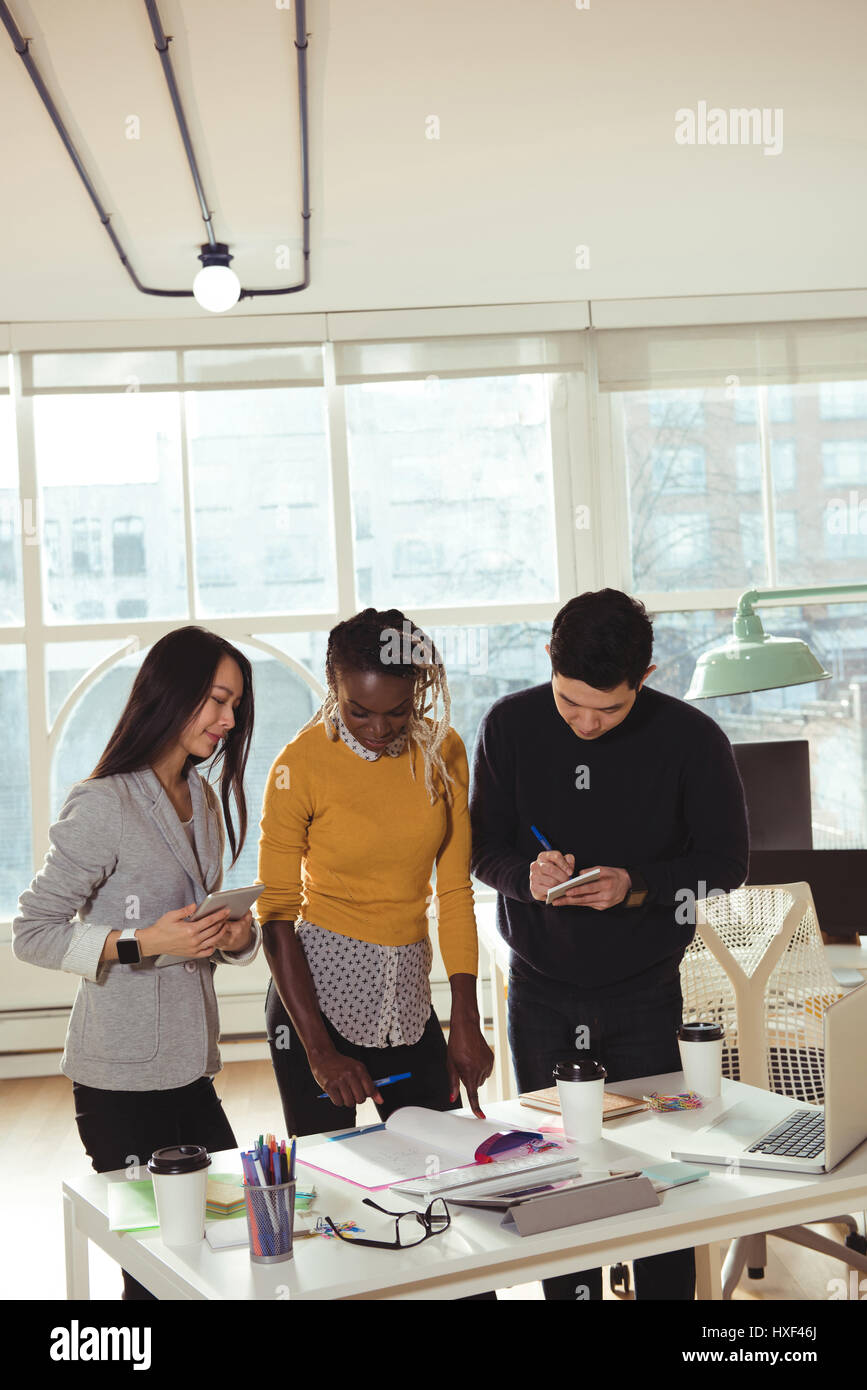 Group of executives working together at desk in office Stock Photo - Alamy