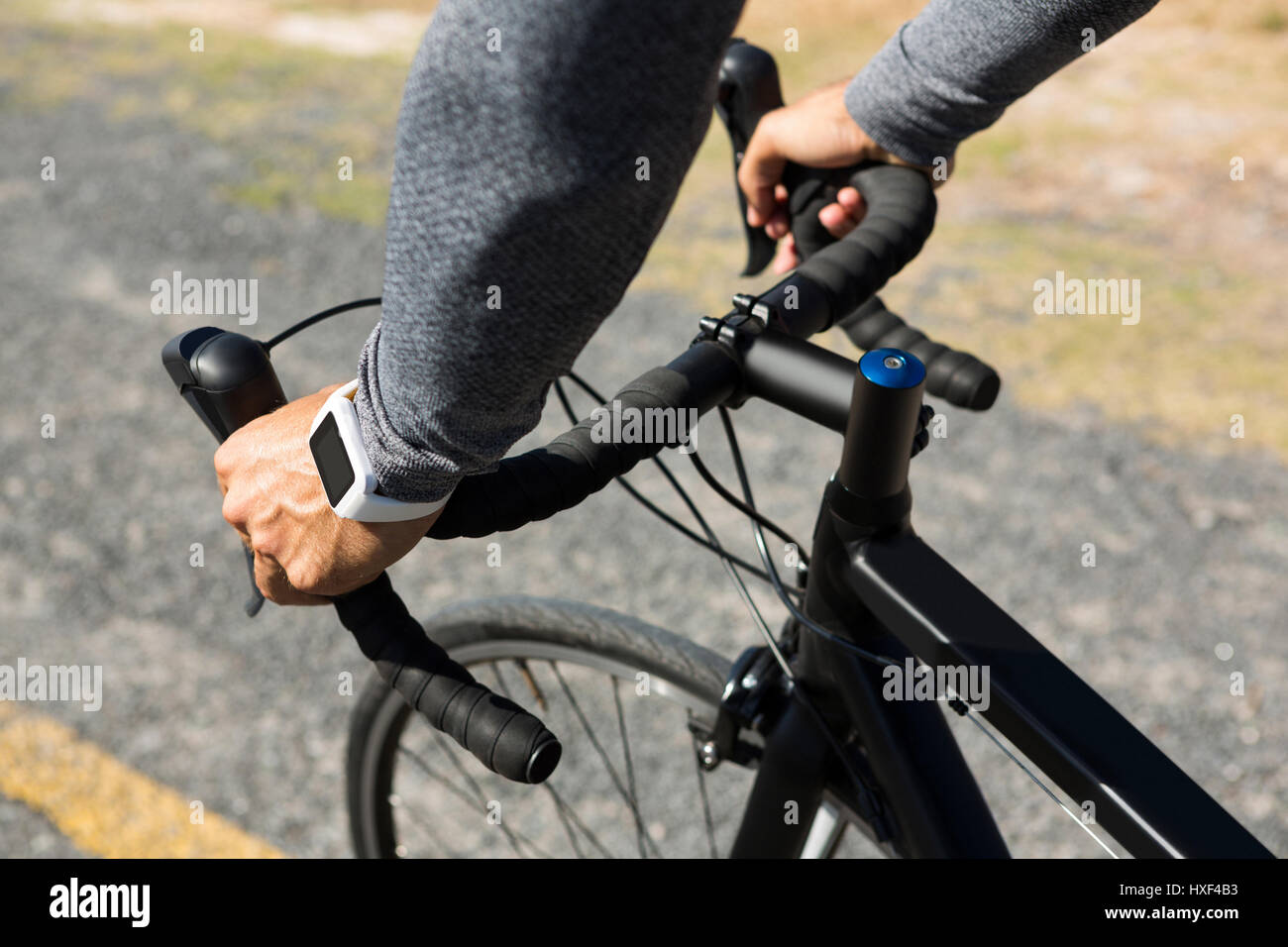 Cropped hand of man riding bicycle on road Stock Photo - Alamy