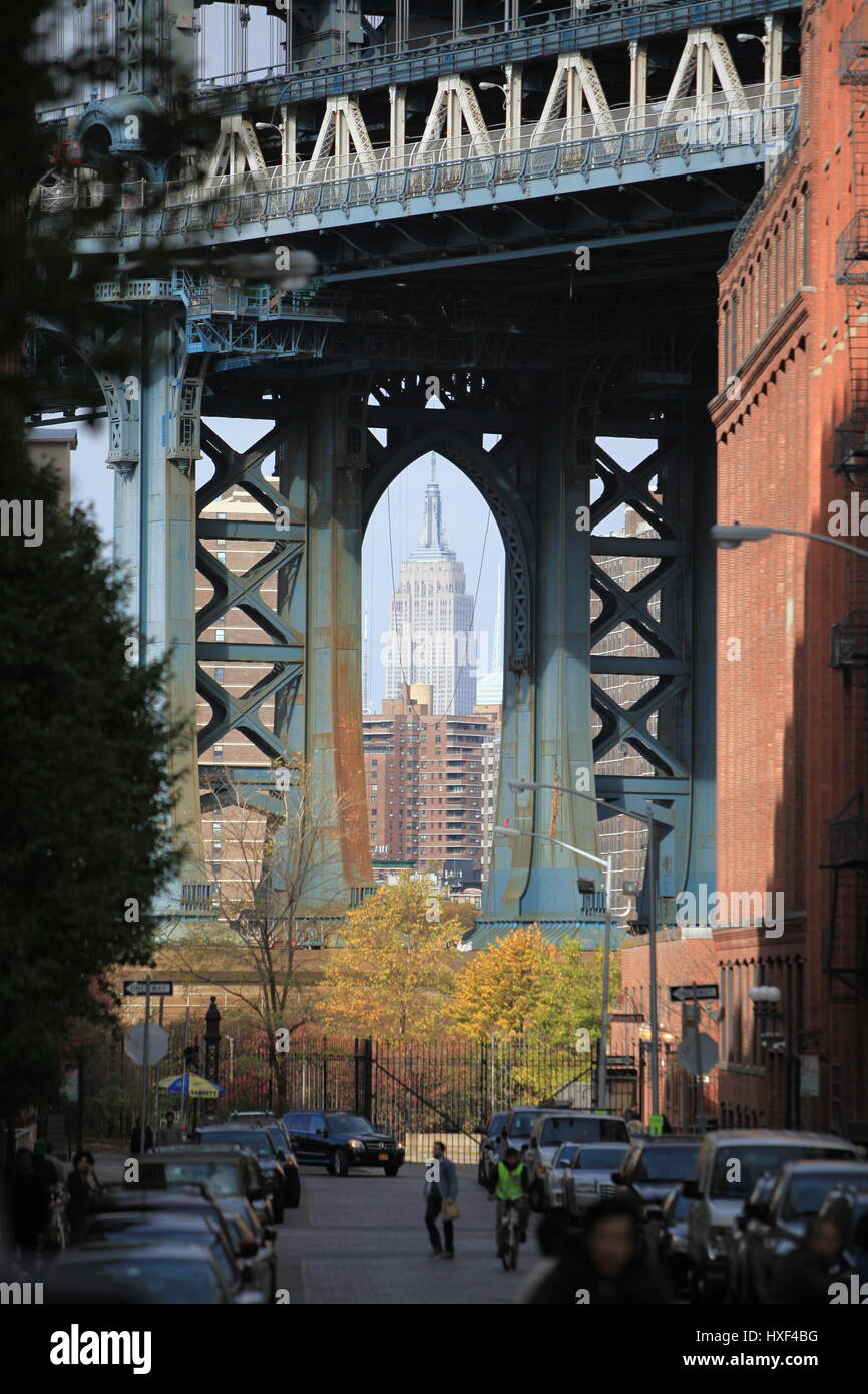 Empire State Building through Manhattan Bridge in New York City. Iconic ...